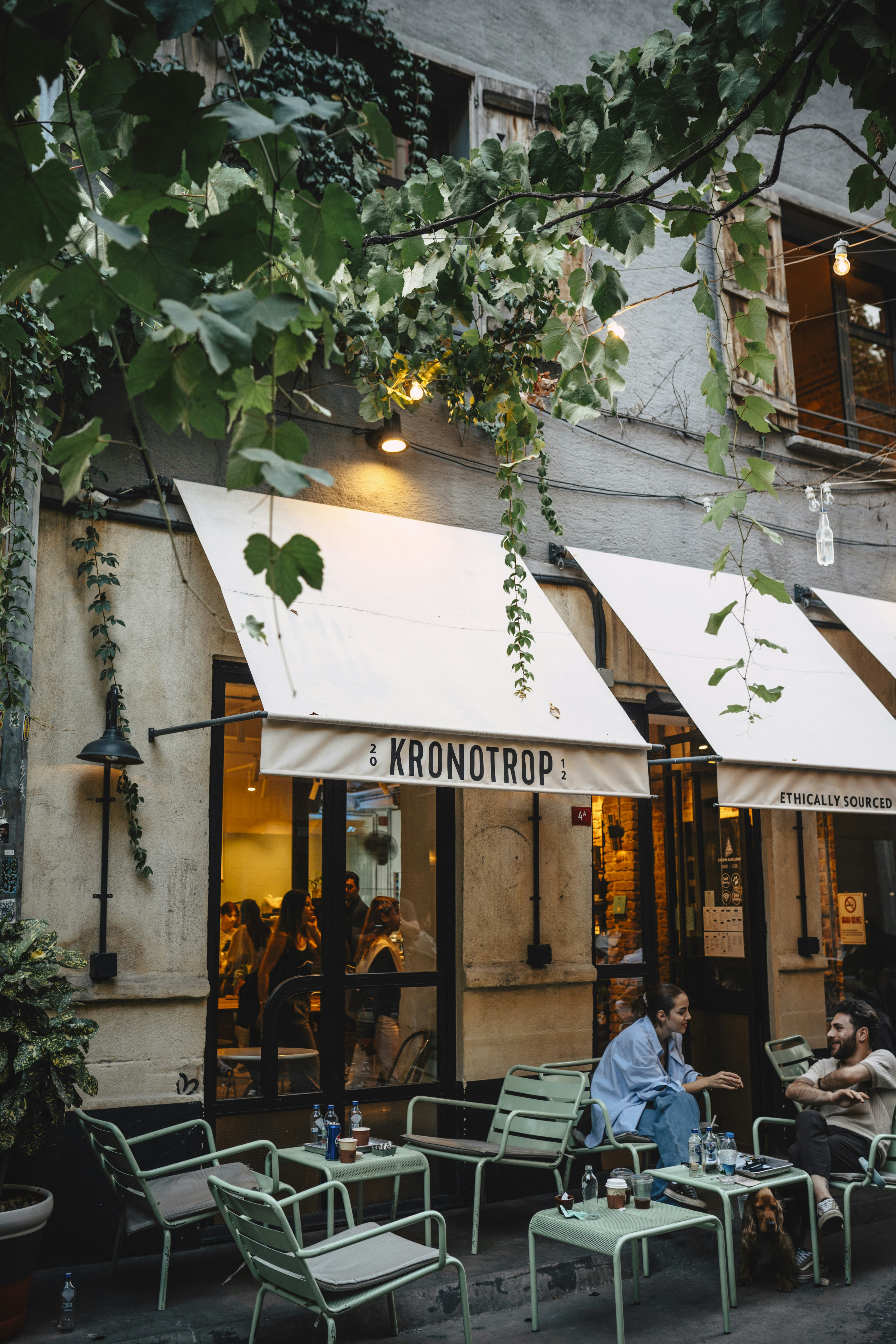 Ivy-Draped Courtyard Café Under White Awnings