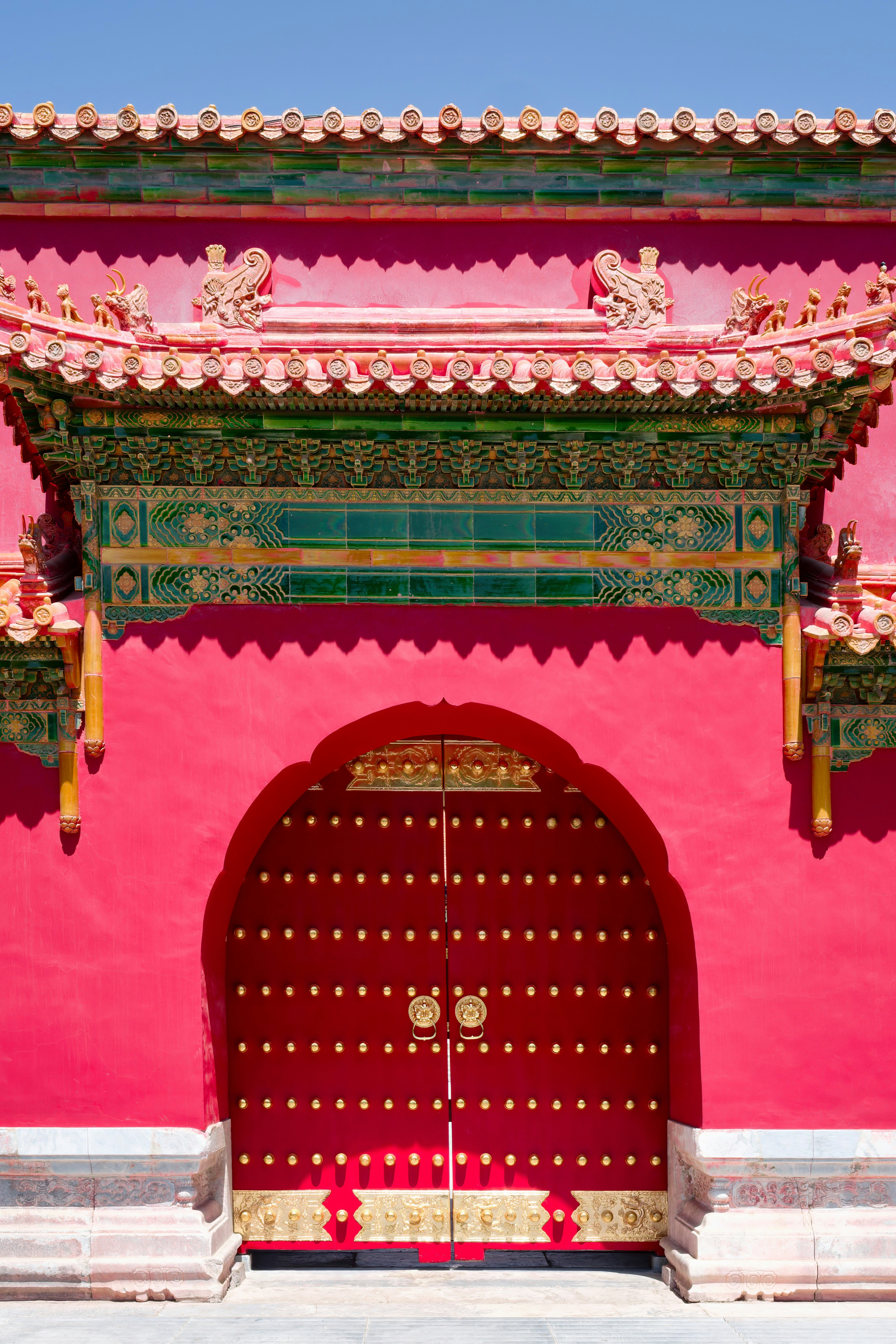 Crimson Gate: Jade Eaves and Gold Studs Framing a Temple Facade