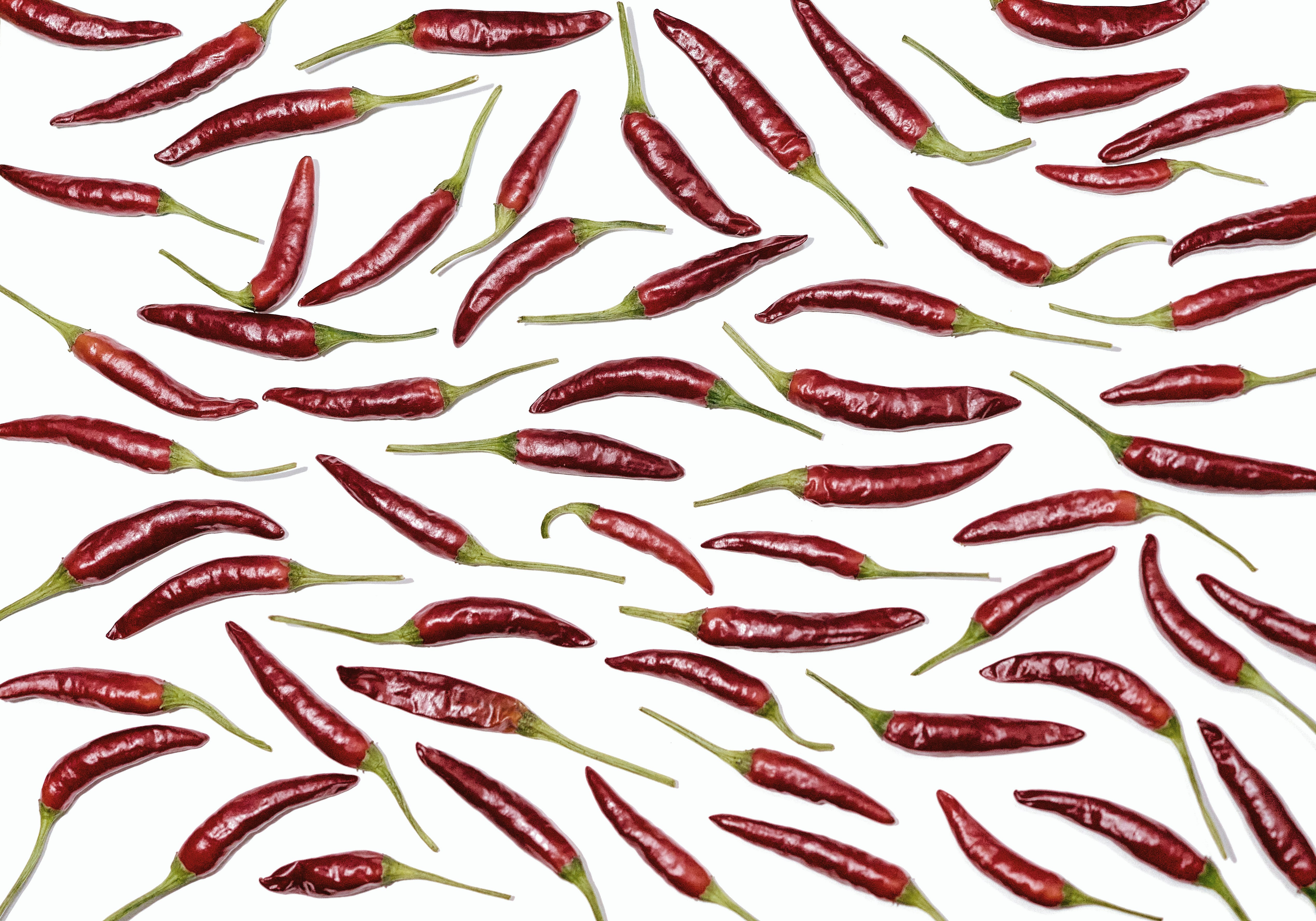 A bunch of red chili peppers on a white background