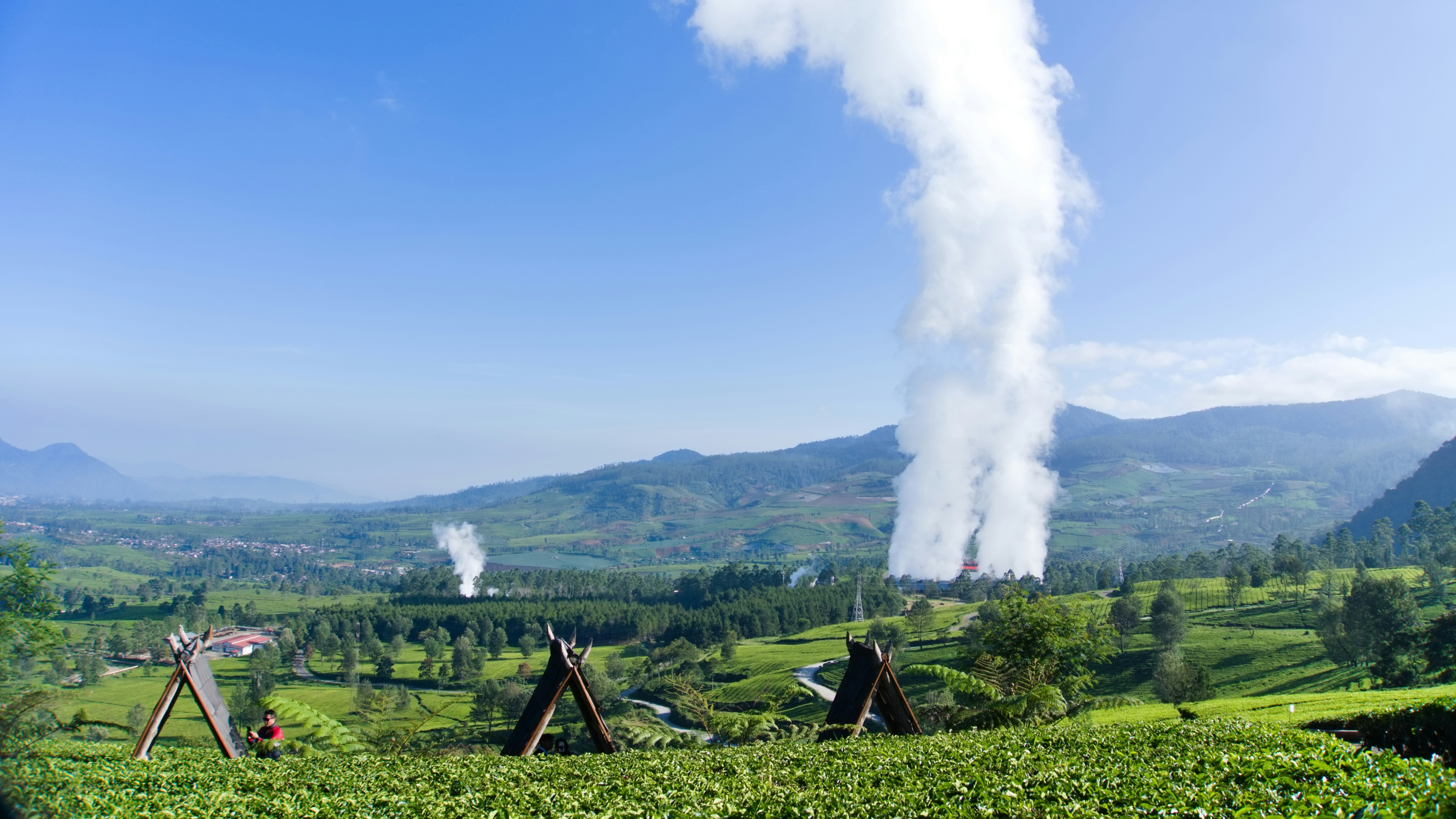 Verdant Valleys and Steam Plumes: A-Frame Foreground, Wide Horizon