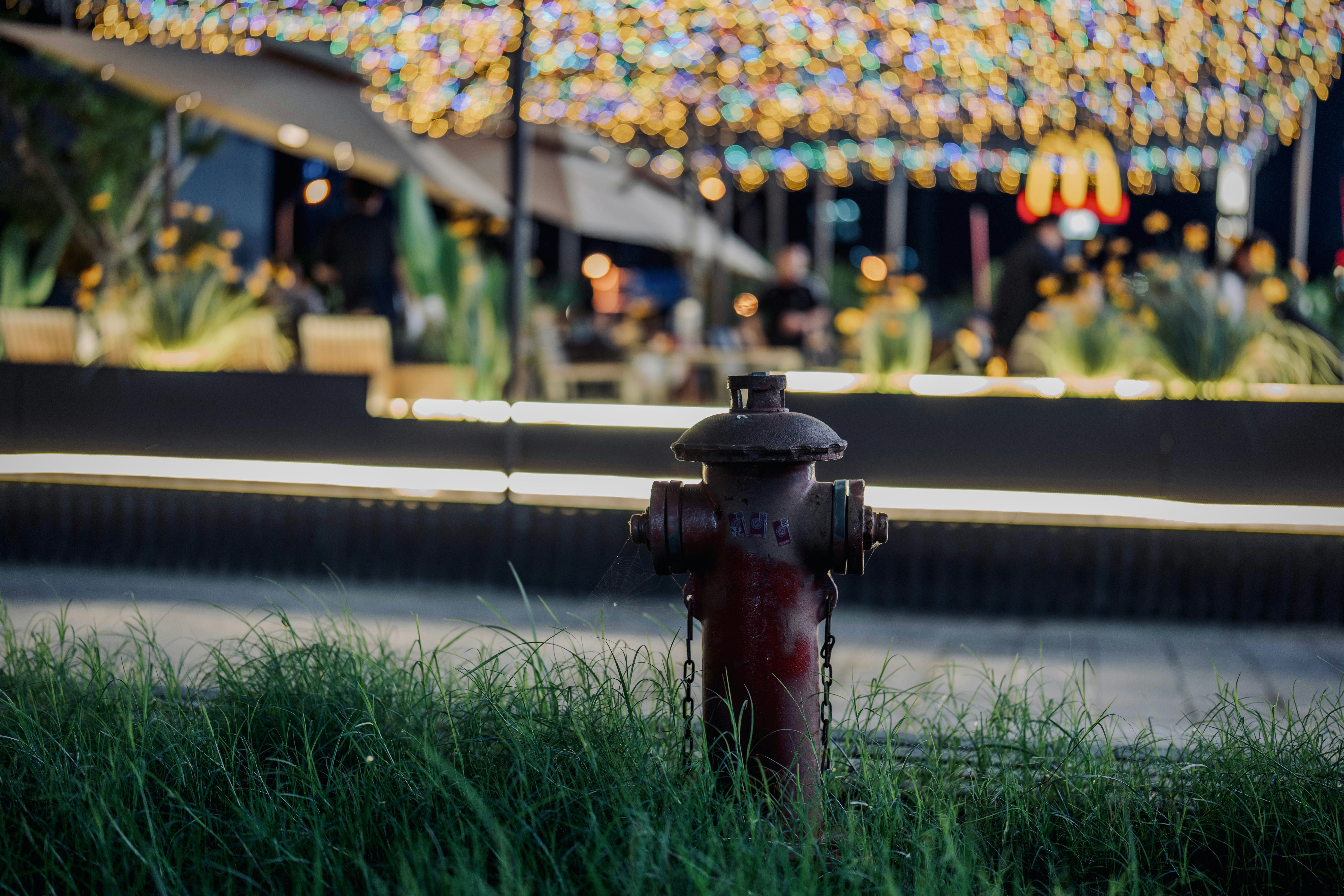 Urban Hydrant in Focus: Neon Lights Blur Behind a Quiet Street