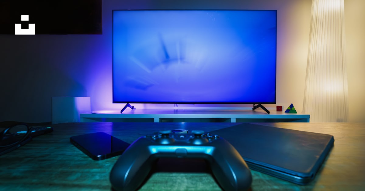 テレビの前に座っているビデオゲームコントローラーの写真 Unsplashのスクリーンの無料画像