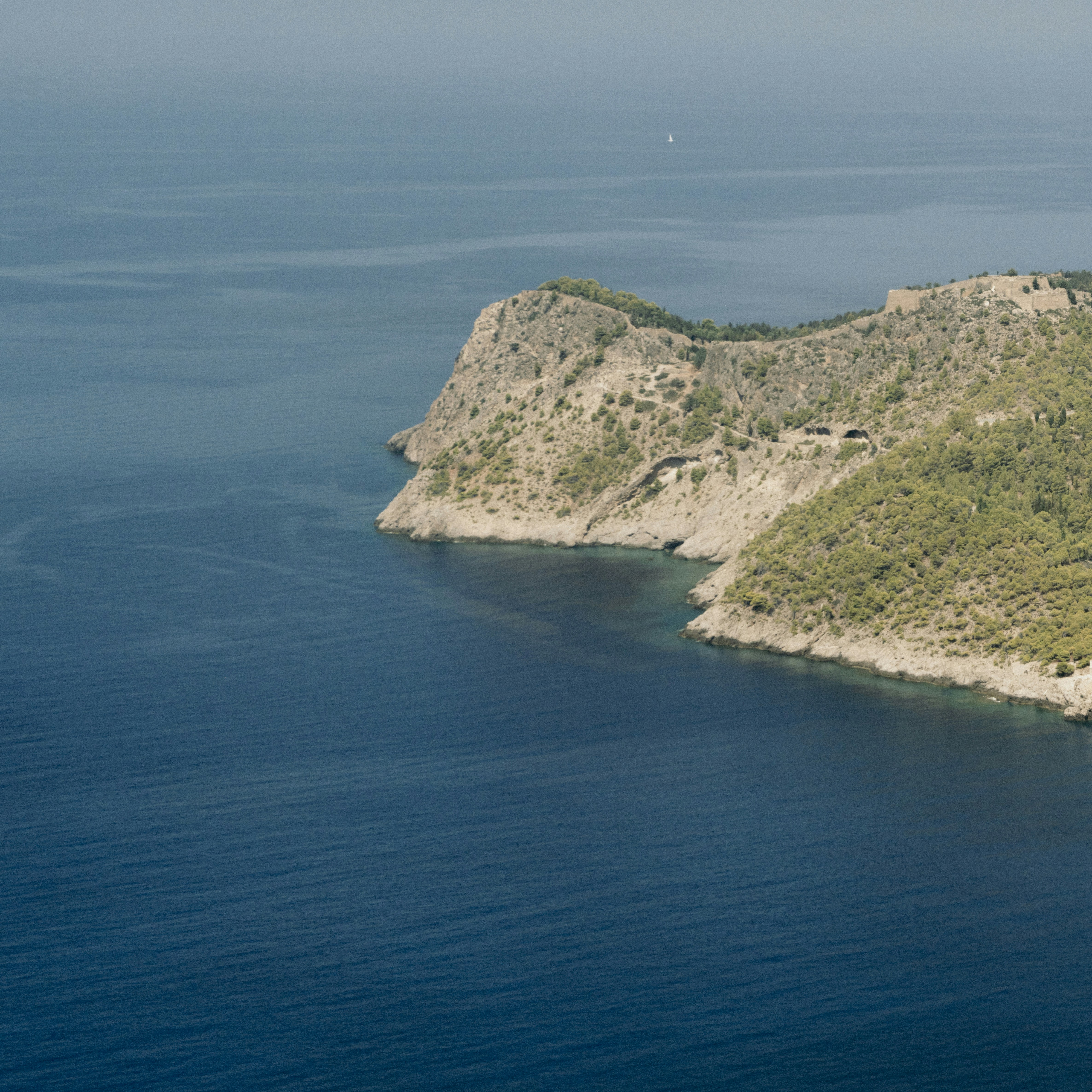 Promontory Over Azure: Cliffside Quiet over a Serene Sea