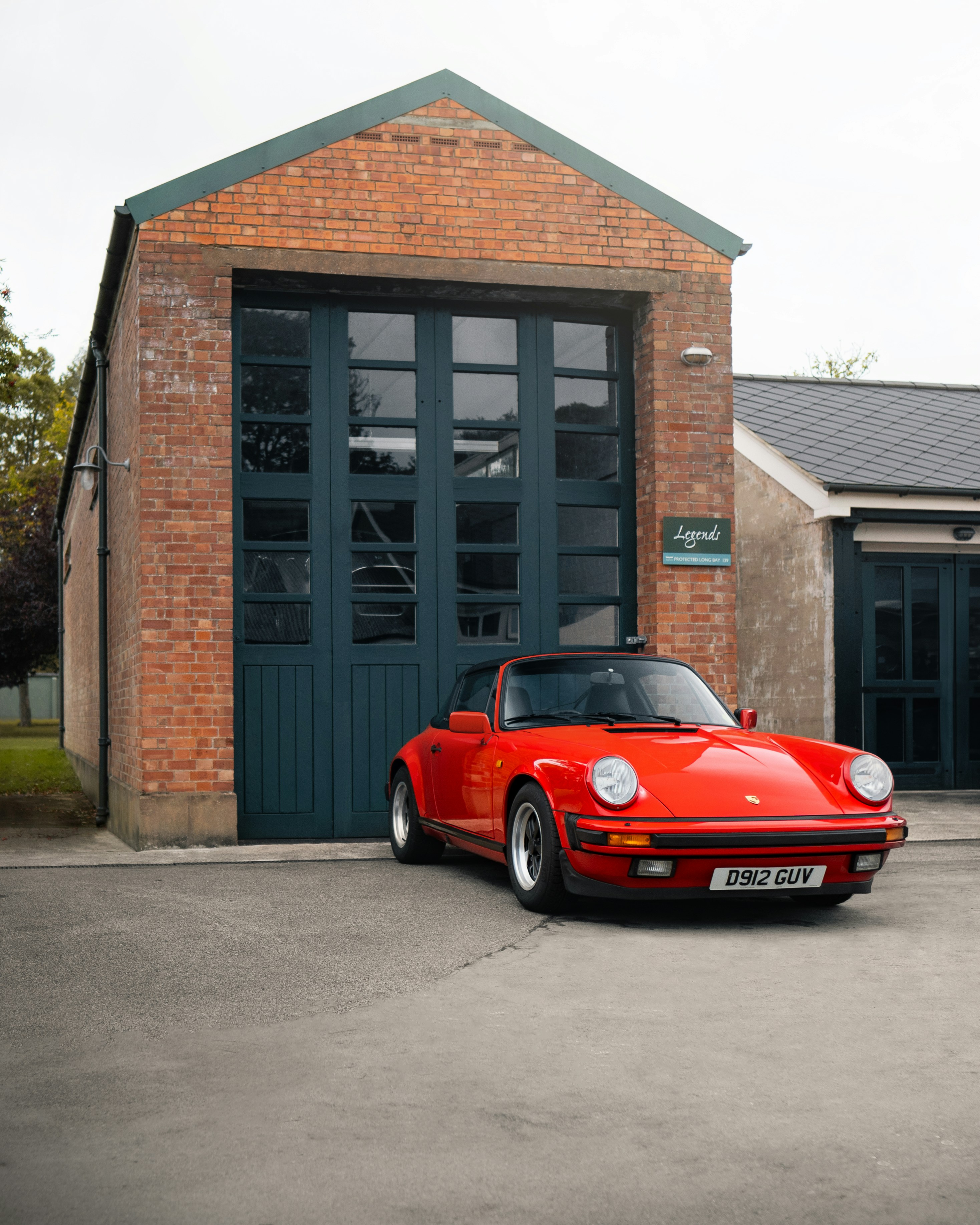 A red car parked in front of a brick building photo – Free Bicester ...