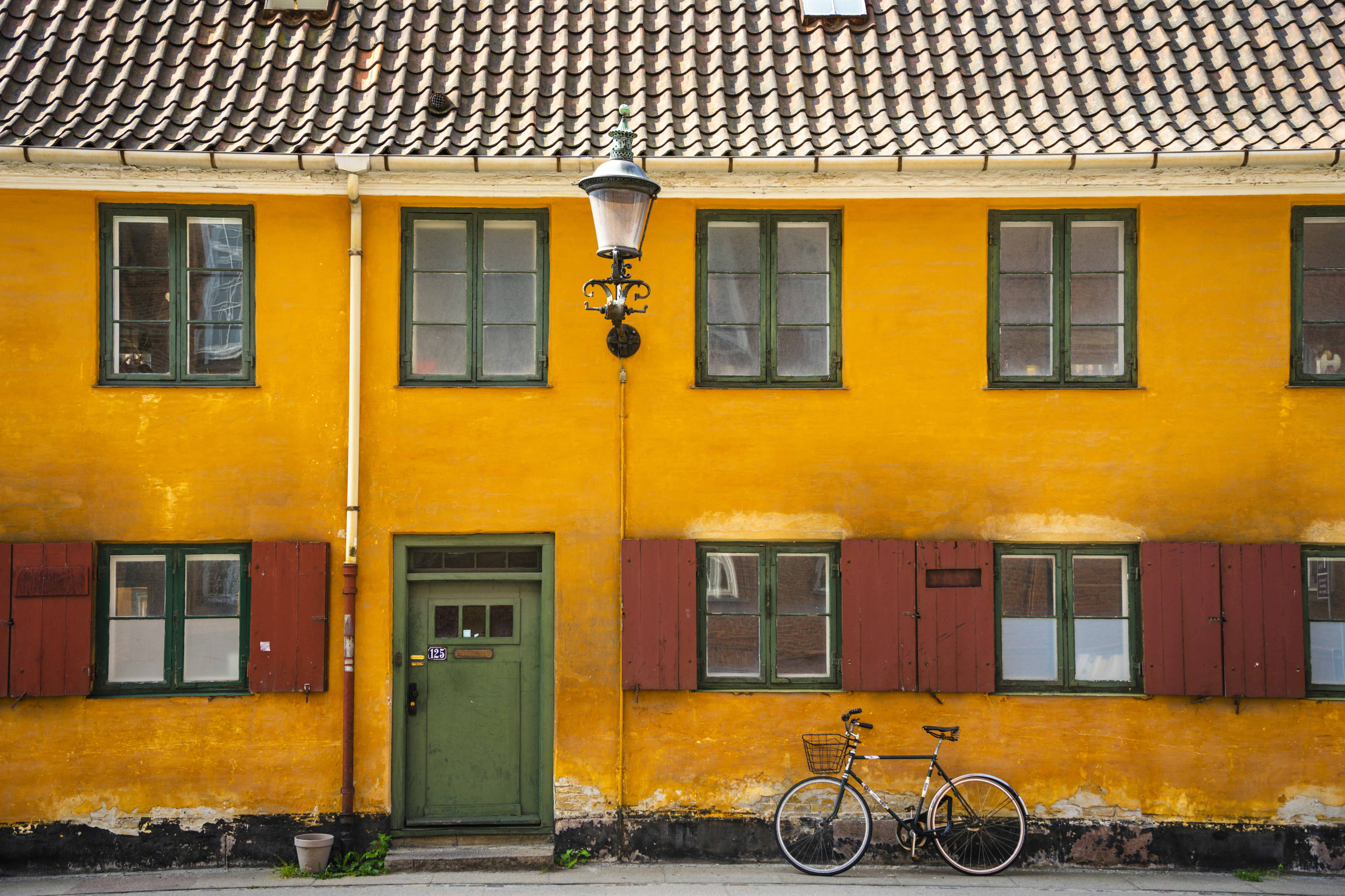 Sunlit Ochre Row: A Quiet Bicycle by a Green Door