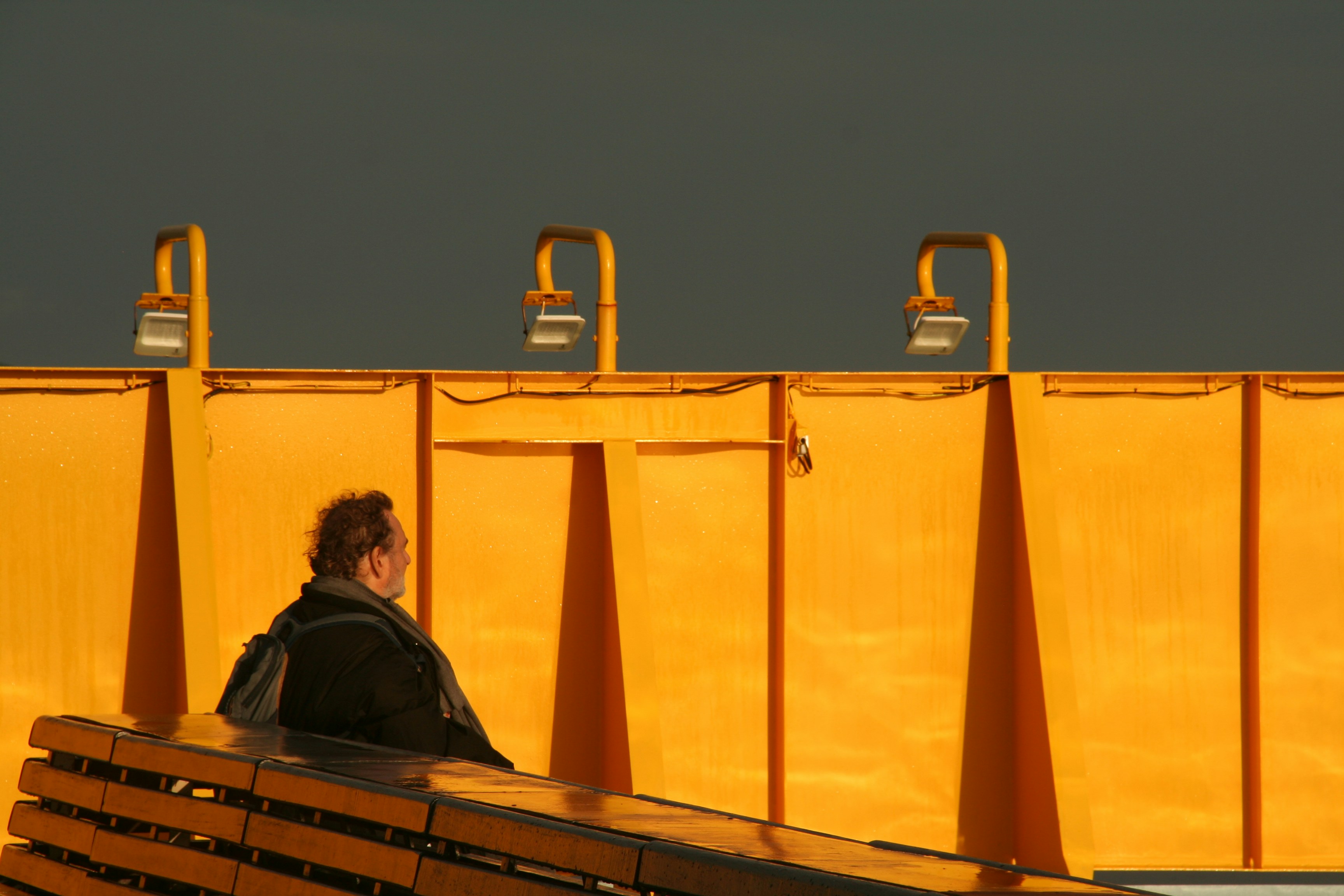 A person sitting on a bench in front of a wall