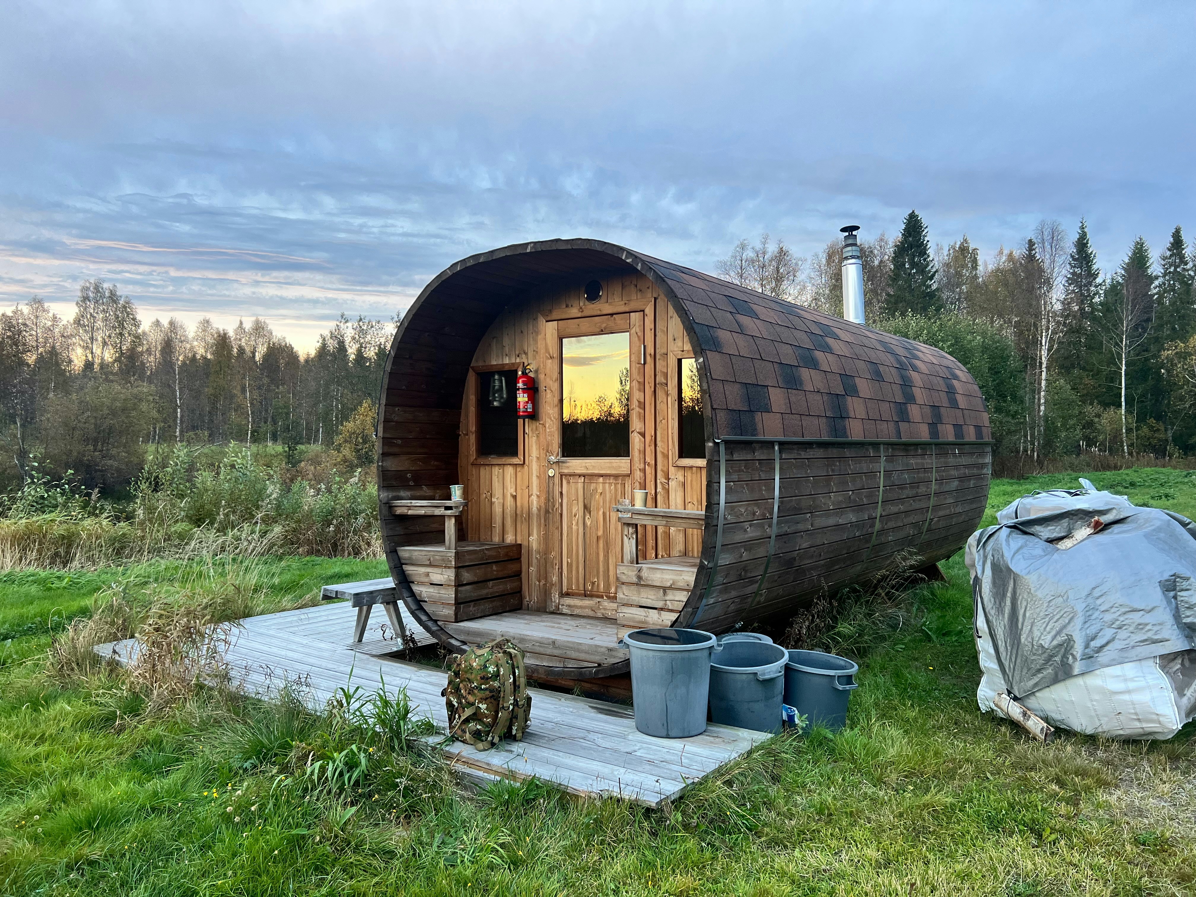 A wooden barrel house sitting on top of a lush green field photo – Free ...