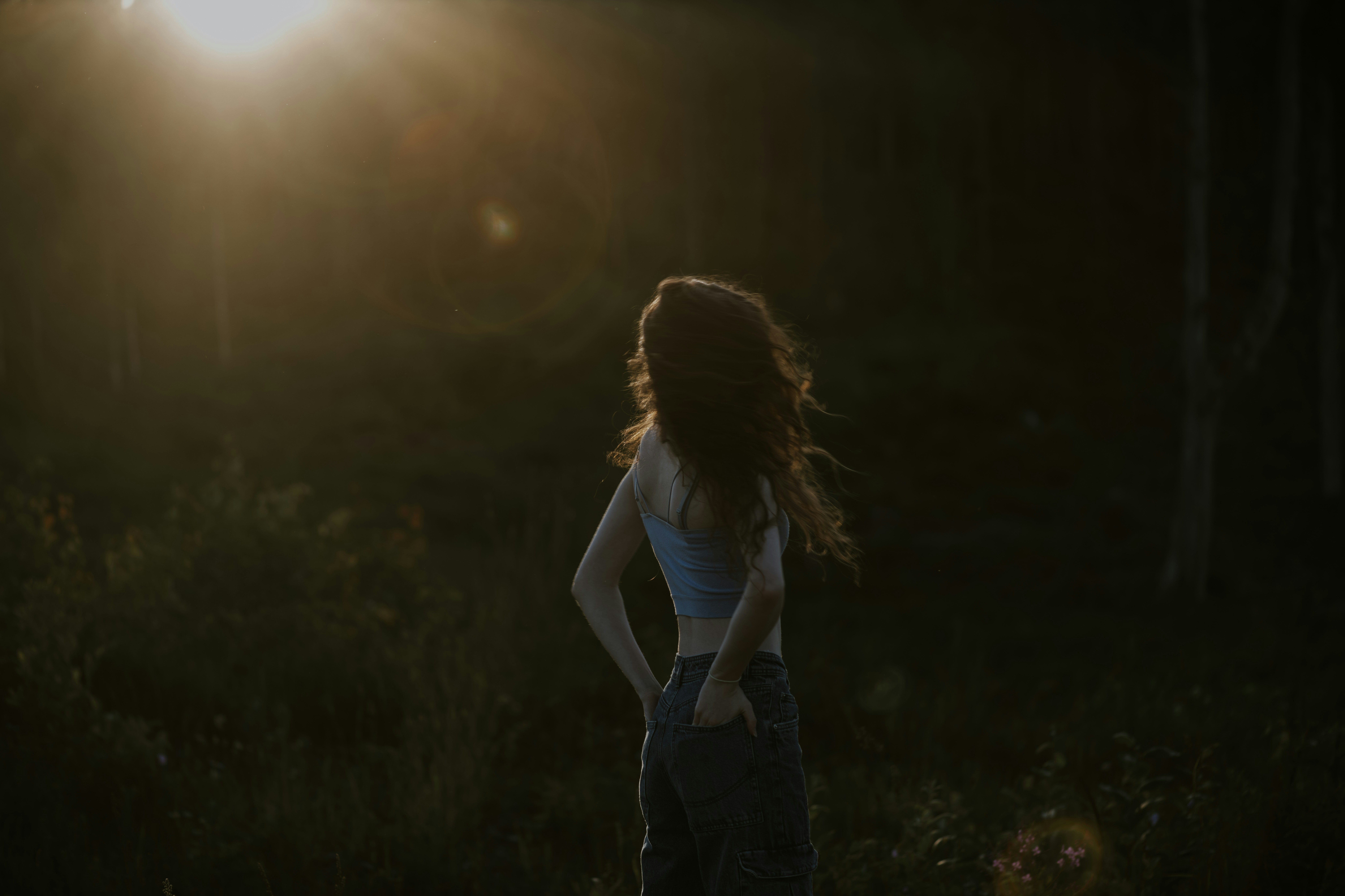 Backlit silhouette: a girl in a sunlit clearing