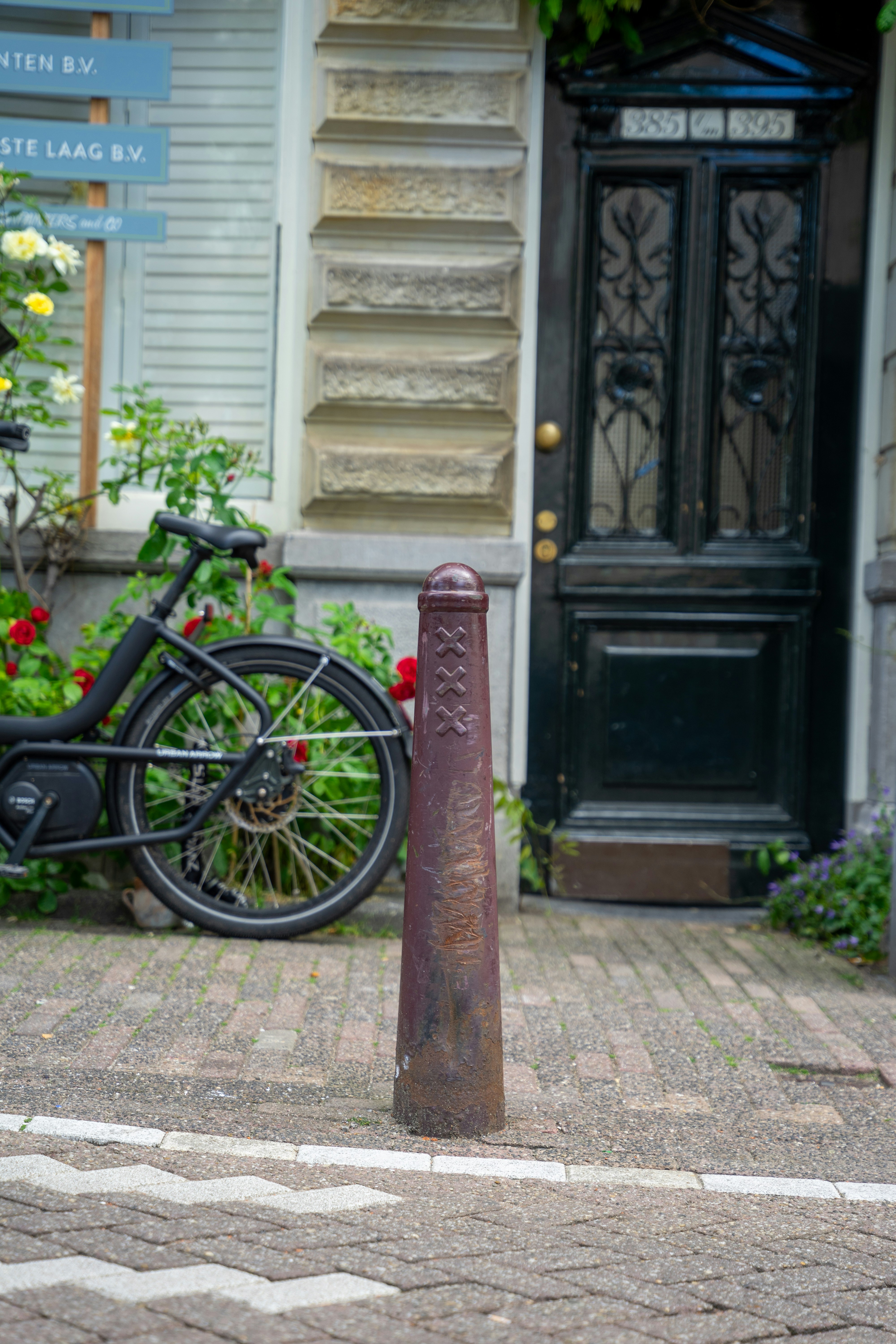Rusted Bollard Guarding a Heritage Door and Quiet Street