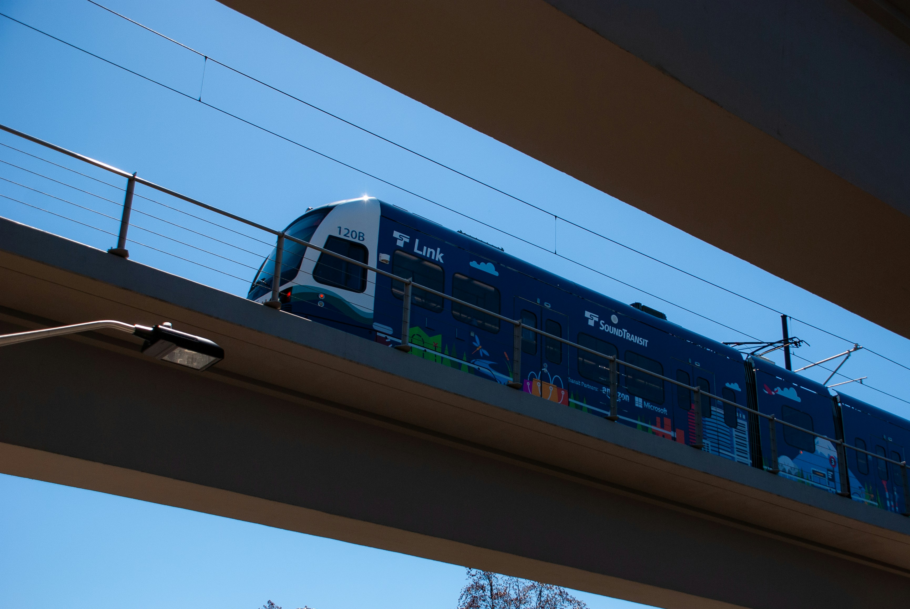 A blue and white train traveling over a bridge photo – Free Wilburton ...
