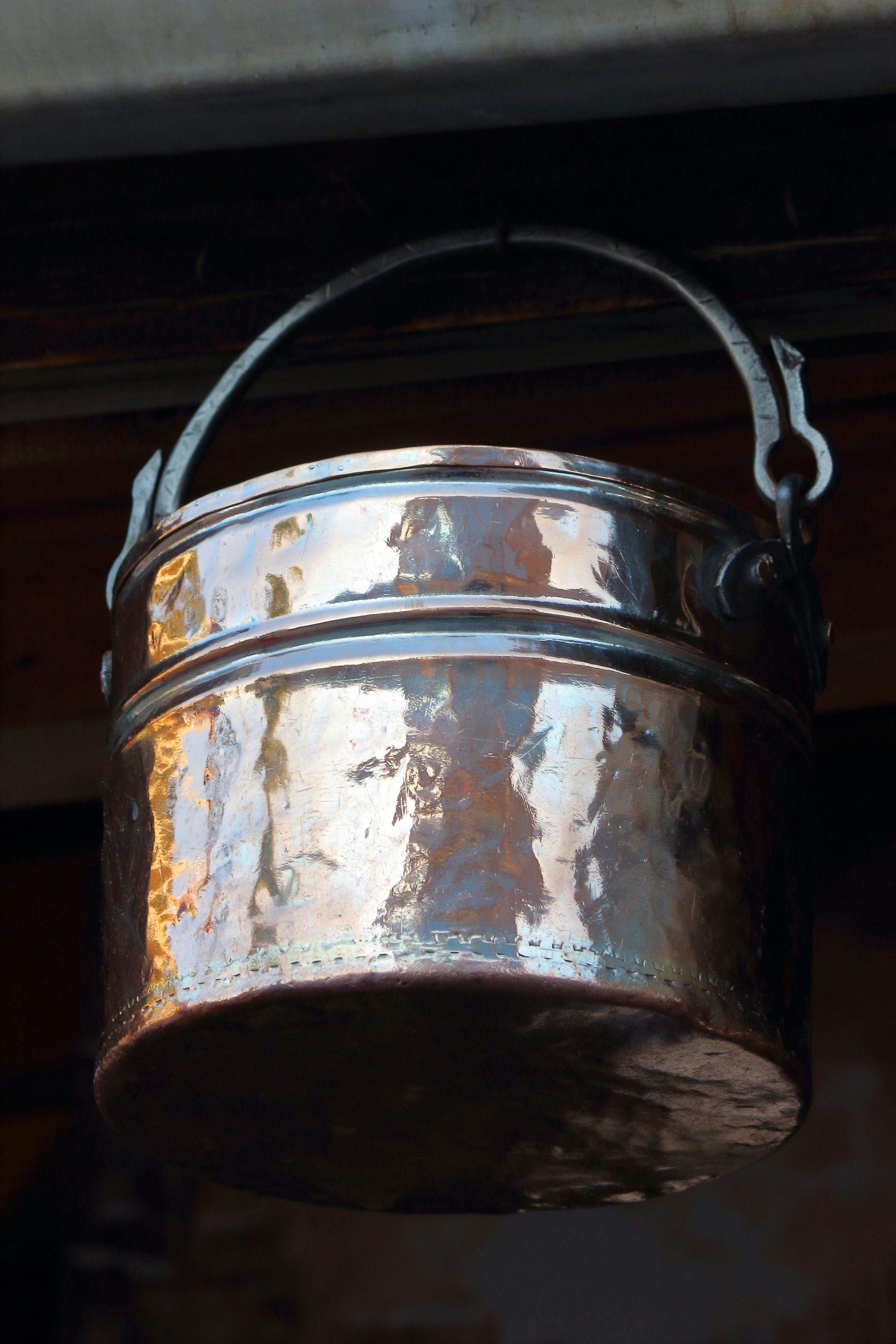 A metal bucket hanging from the side of a building photo – Free Can ...