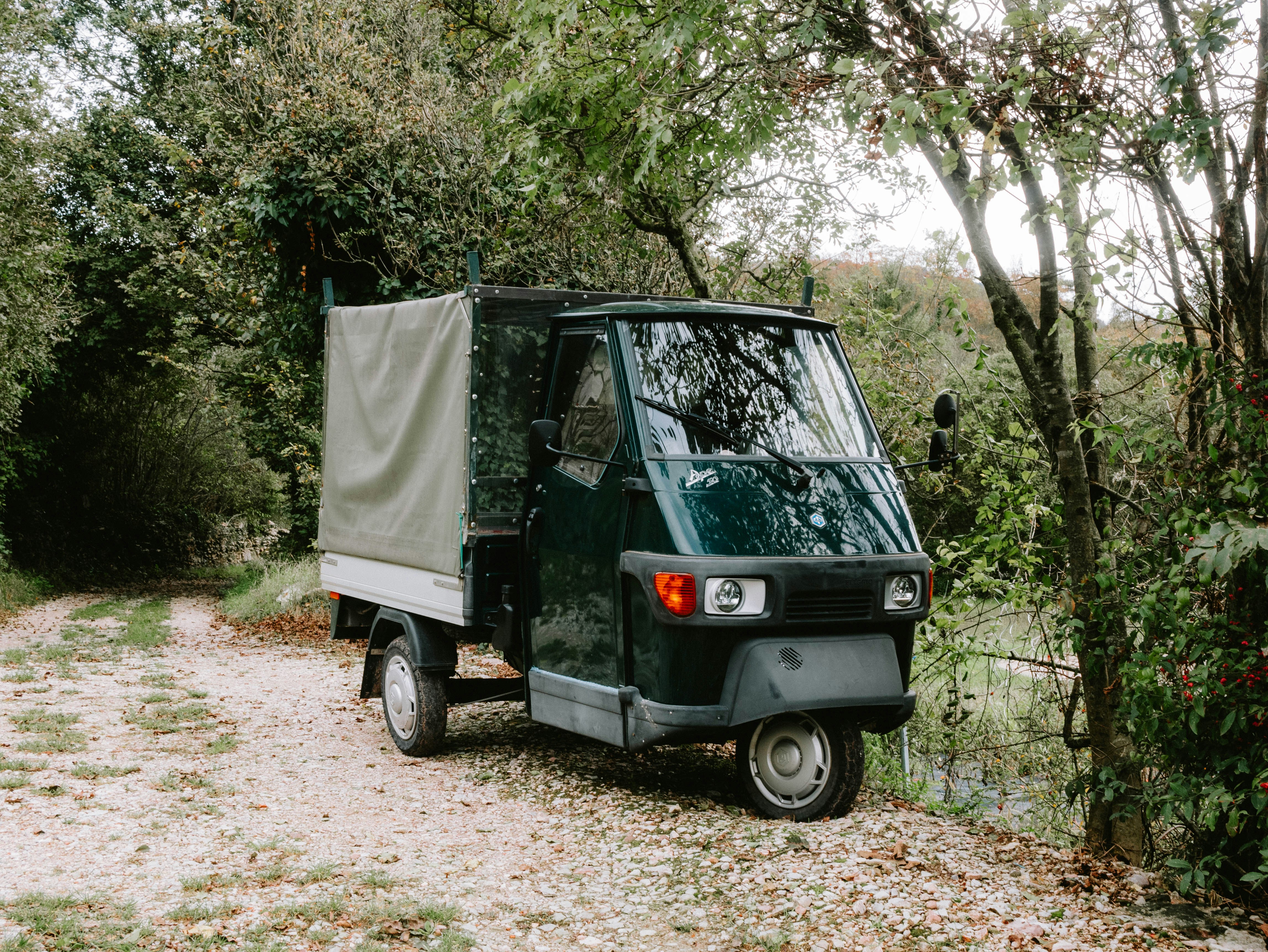 Forest Freight: A Compact Green Cargo Truck on a Gravel Path