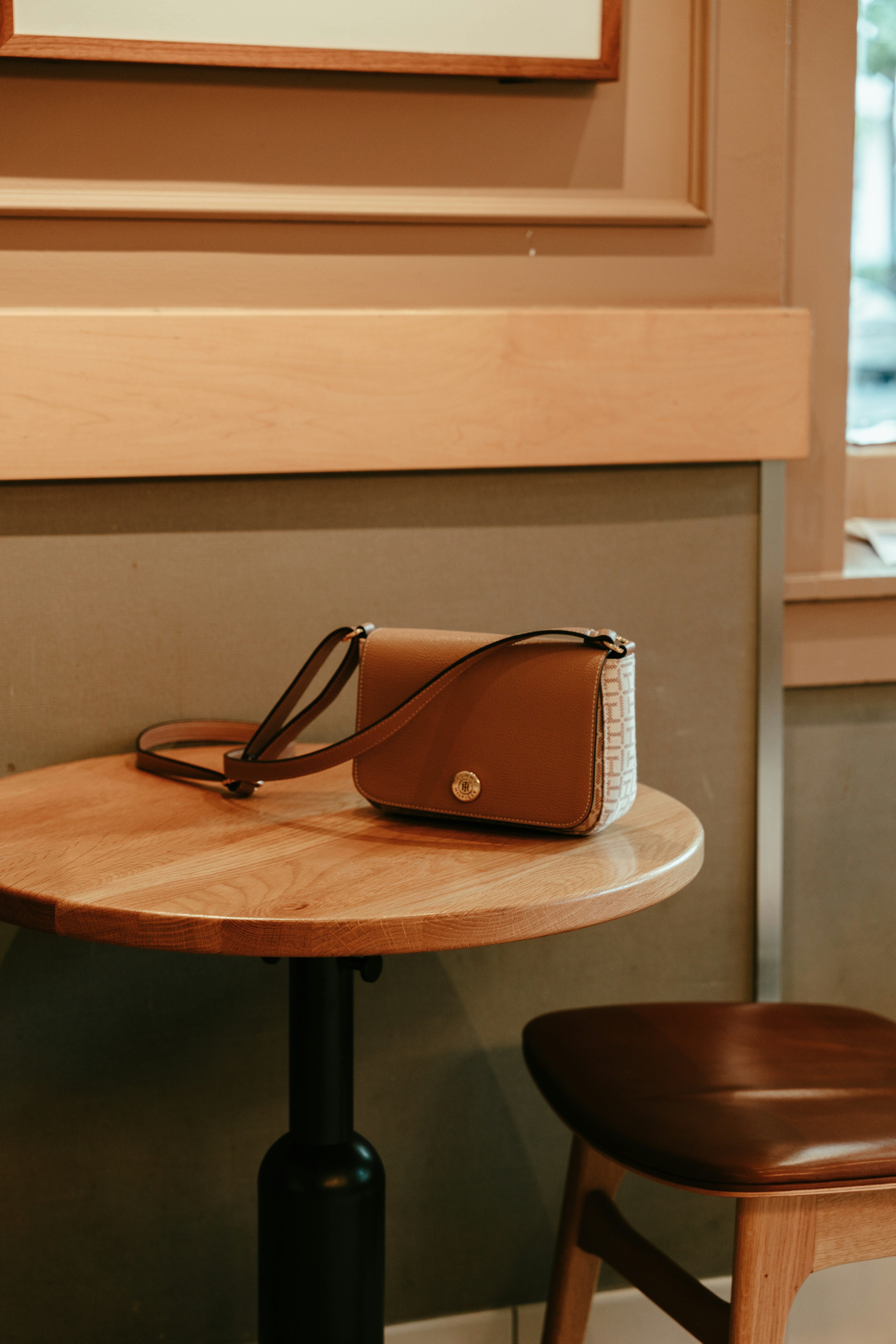 Round Table Reverie: A Brown Leather Crossbody in Warm Café Light