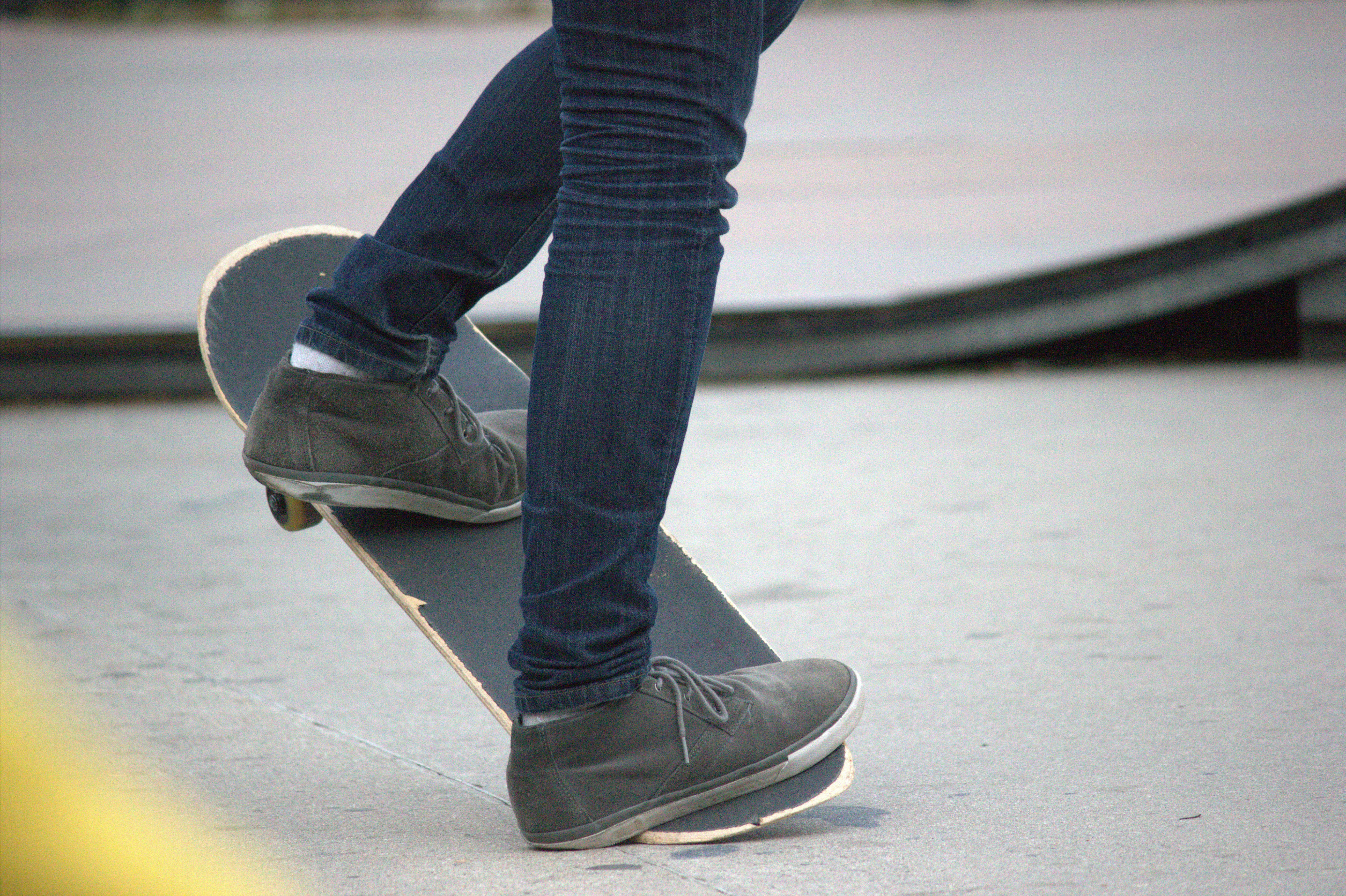 A man riding a skateboard down a sidewalk photo – Free Sneaker Image on ...