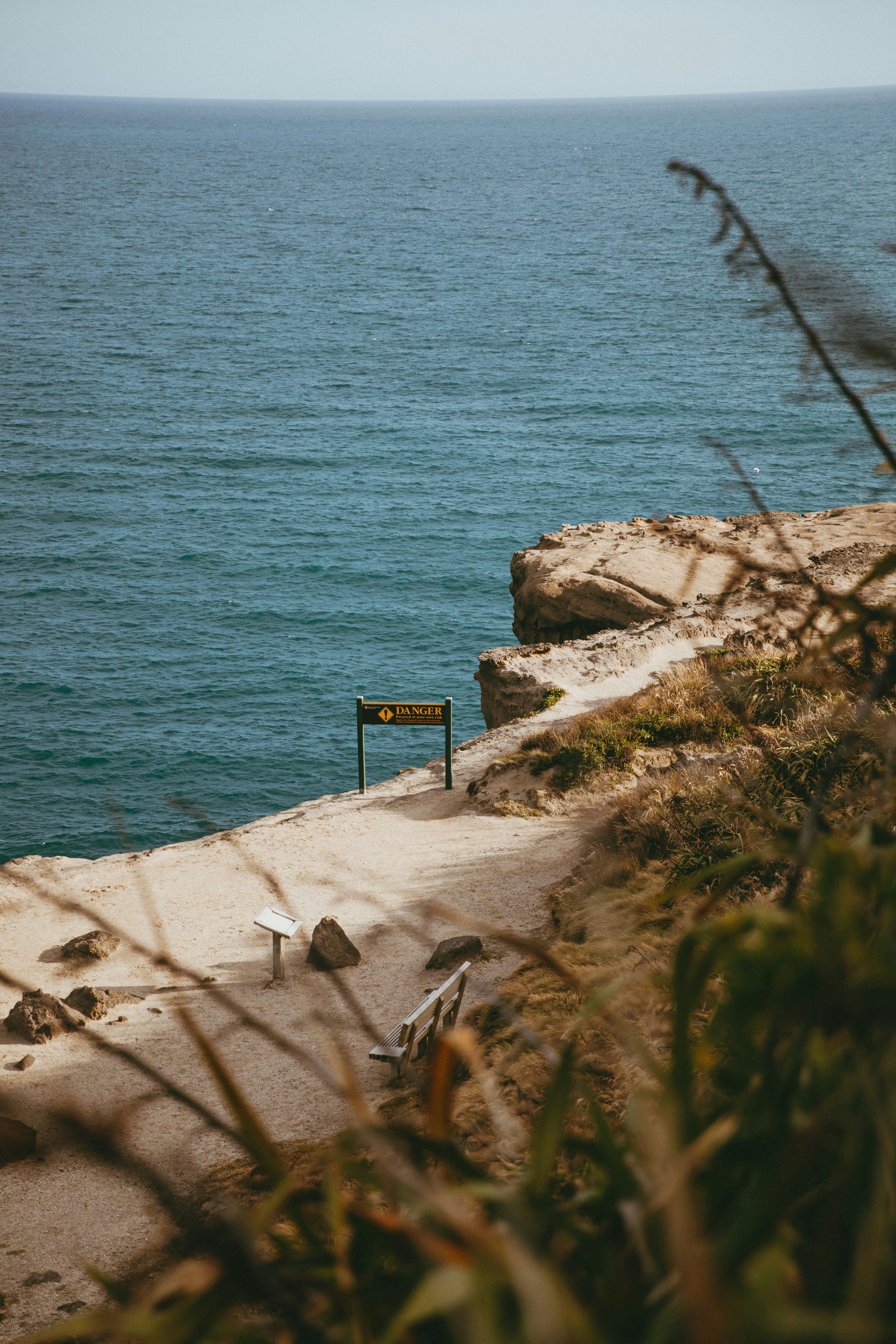 A bench sitting on the edge of a cliff overlooking the ocean photo ...