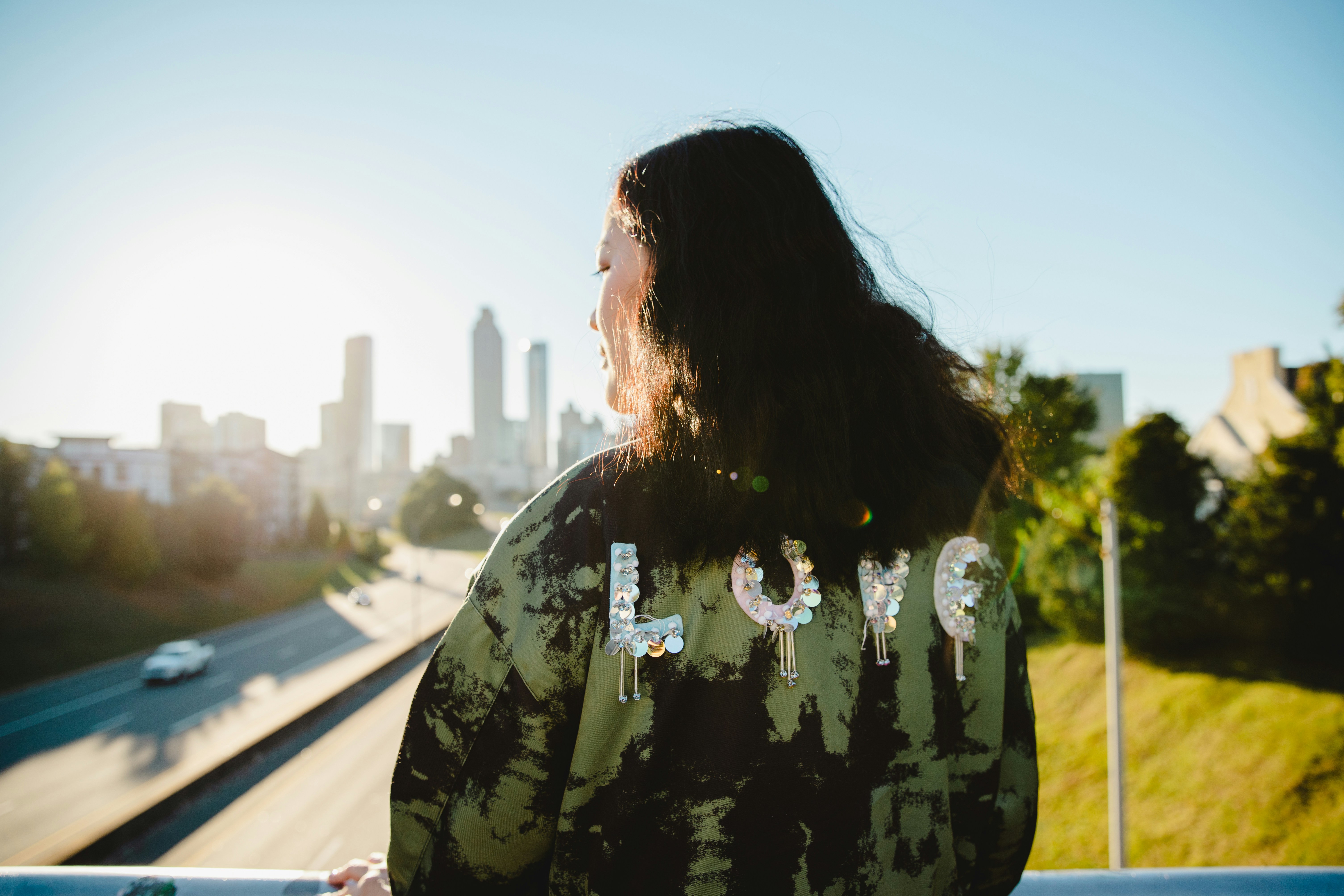 A person standing on a rail with a city in the background photo – Free ...