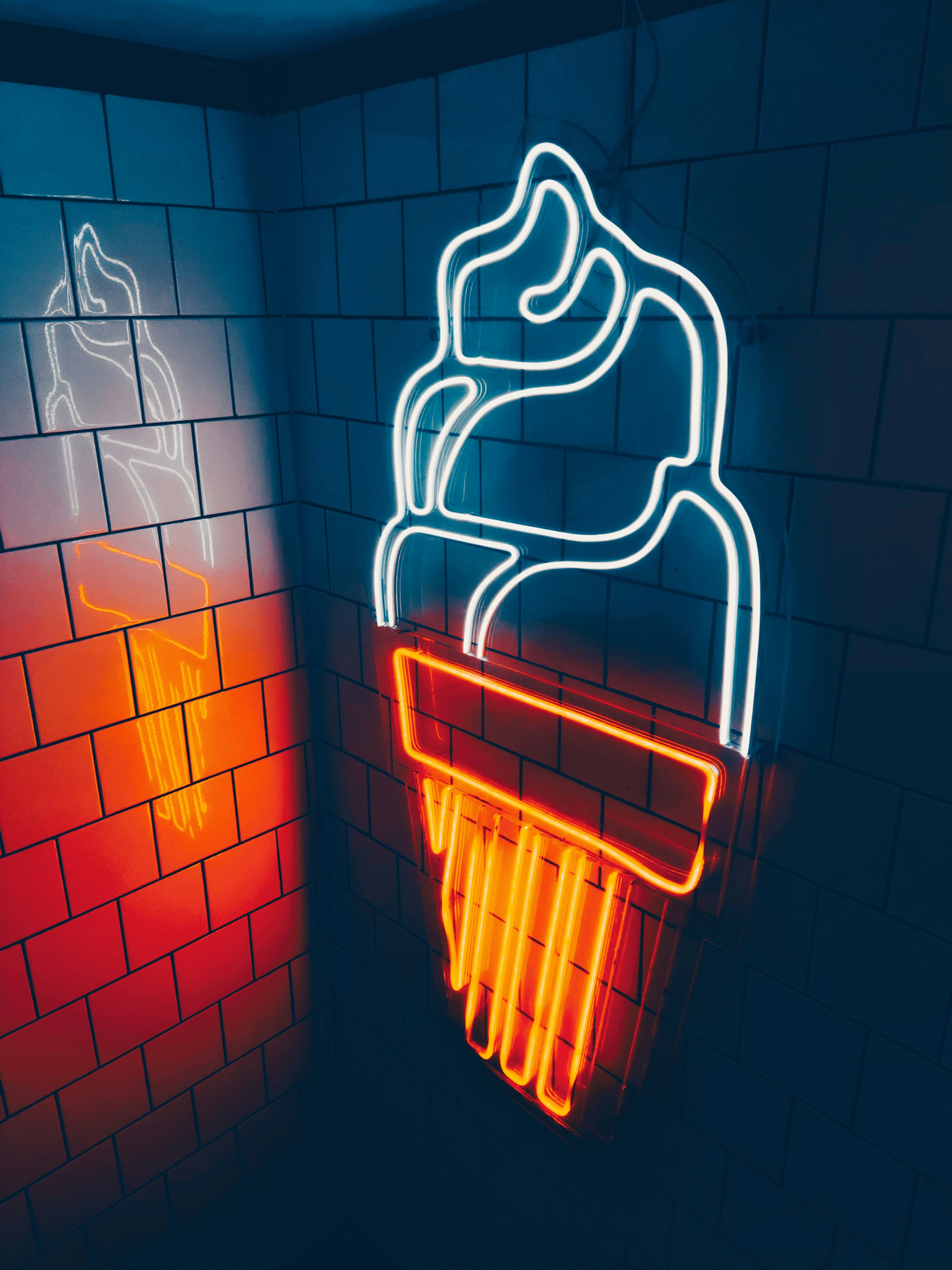 A neon sign in the corner of a bathroom