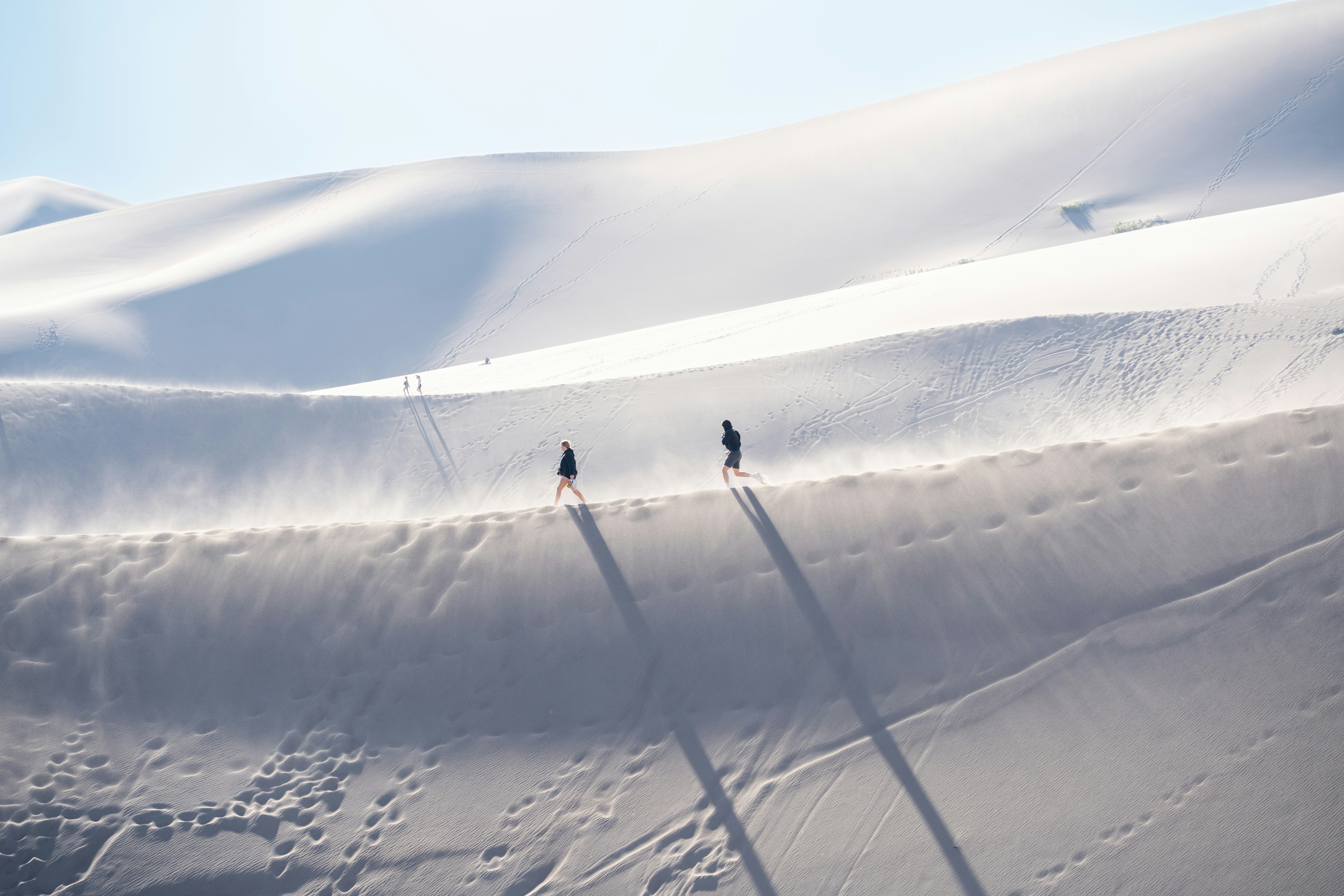 A group of people riding skis down a snow covered slope photo – Free ...