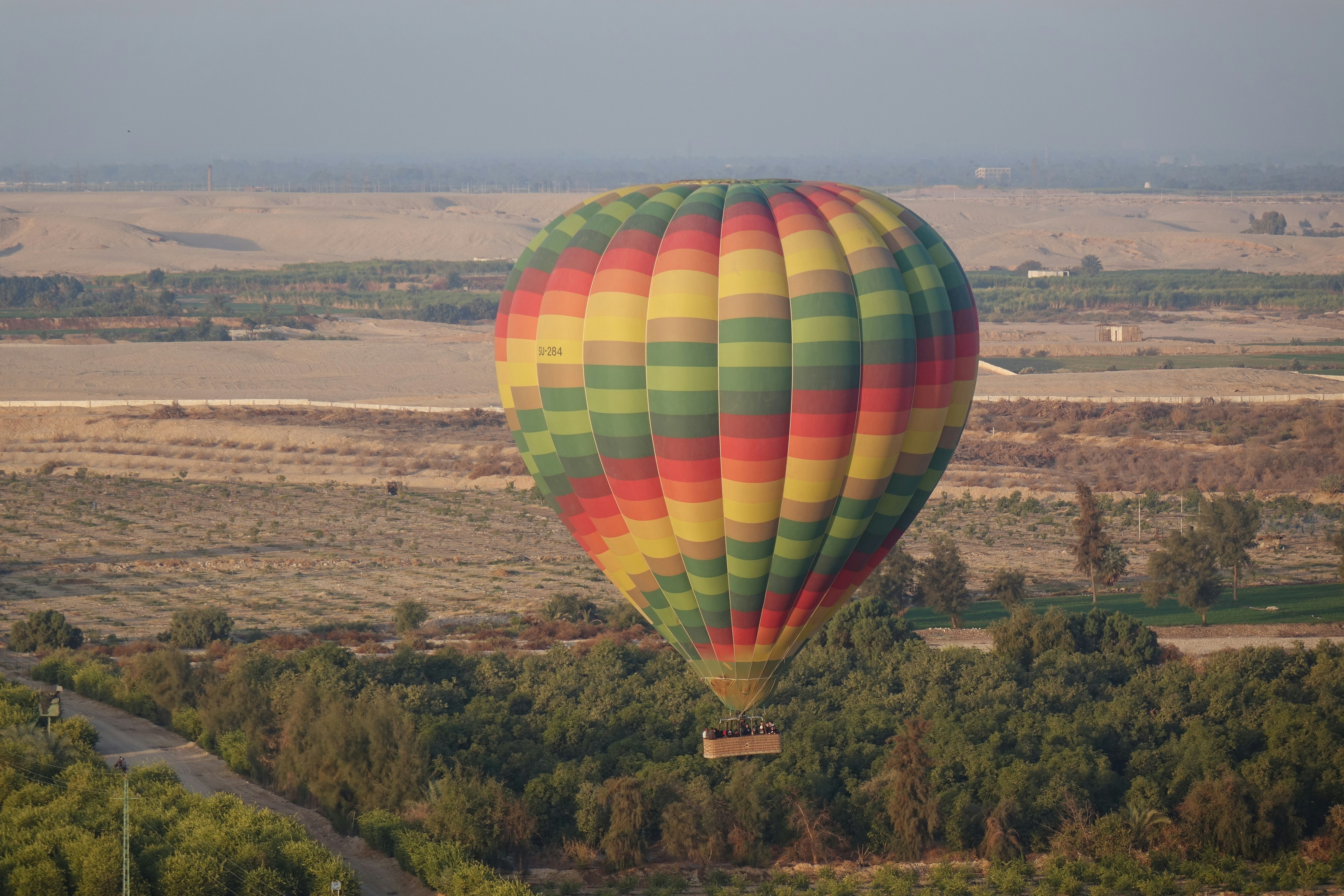 Un globo aerostático volando sobre un exuberante campo verde foto ...