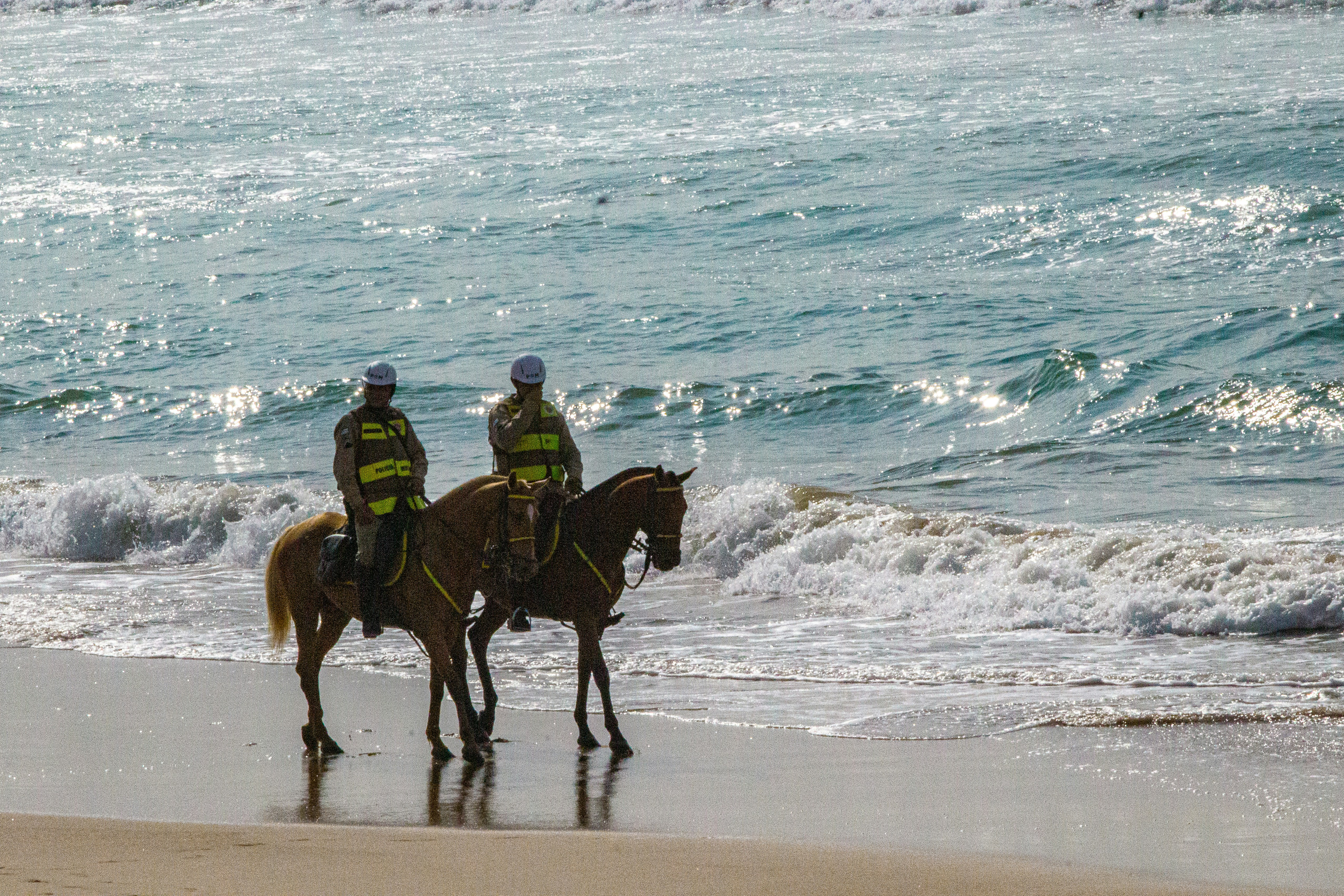 Riders in Hi-Vis Patrol Along a Quiet Beach