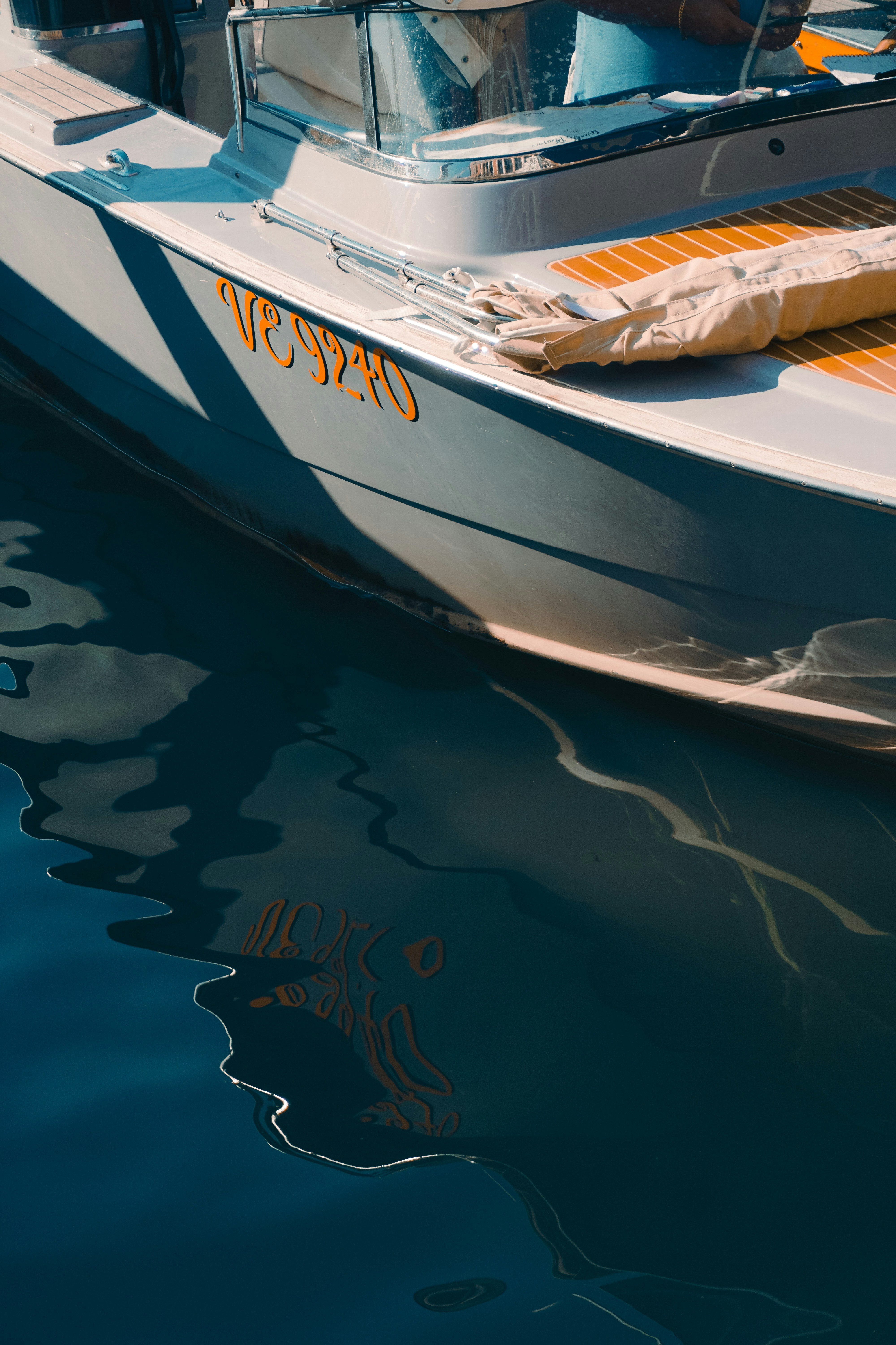 Copper Script on Sunlit Hull: Quiet Marina Reflections