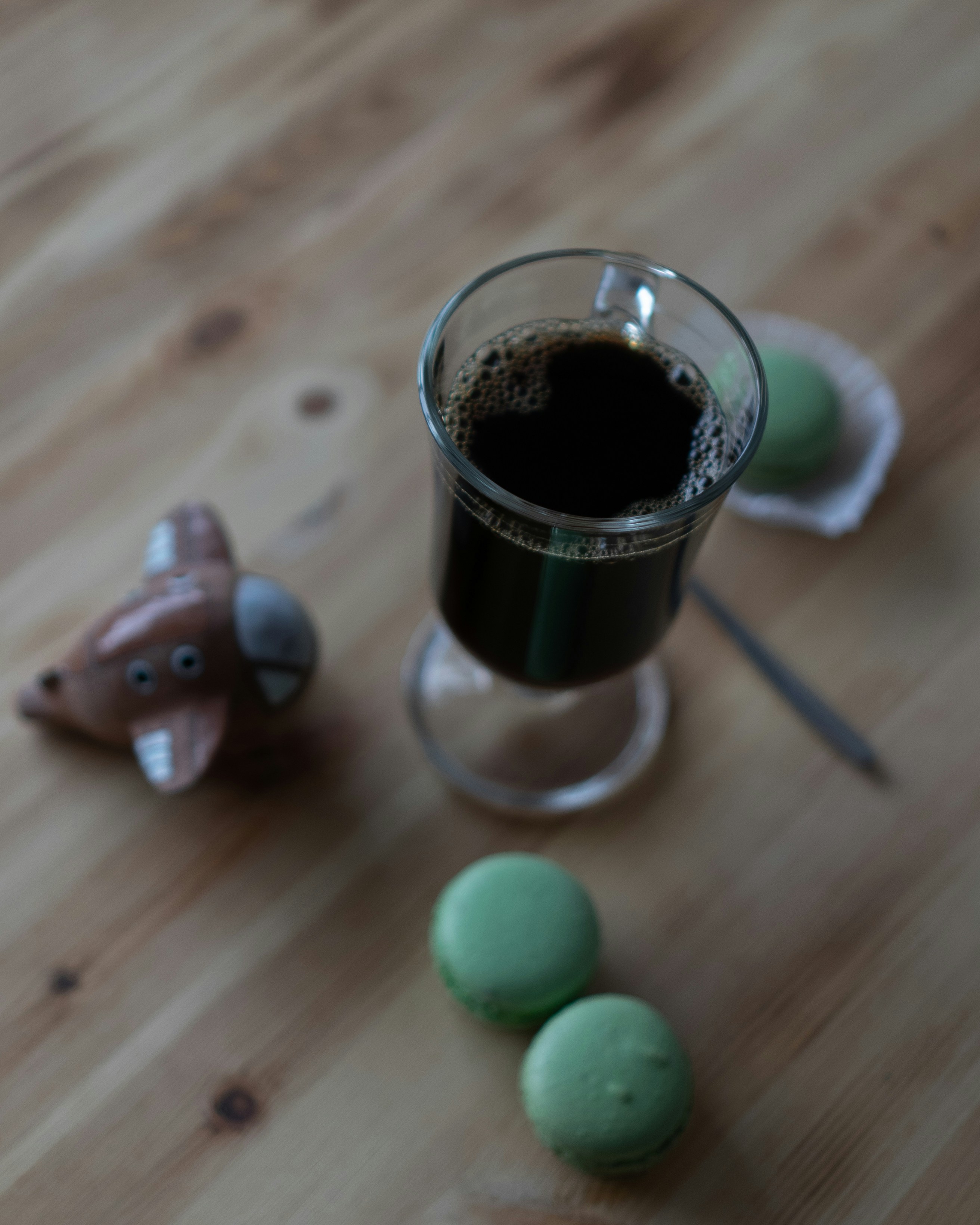 Dark Coffee, Emerald Macarons, and a Wooden Table: A Quiet Still-Life Moment