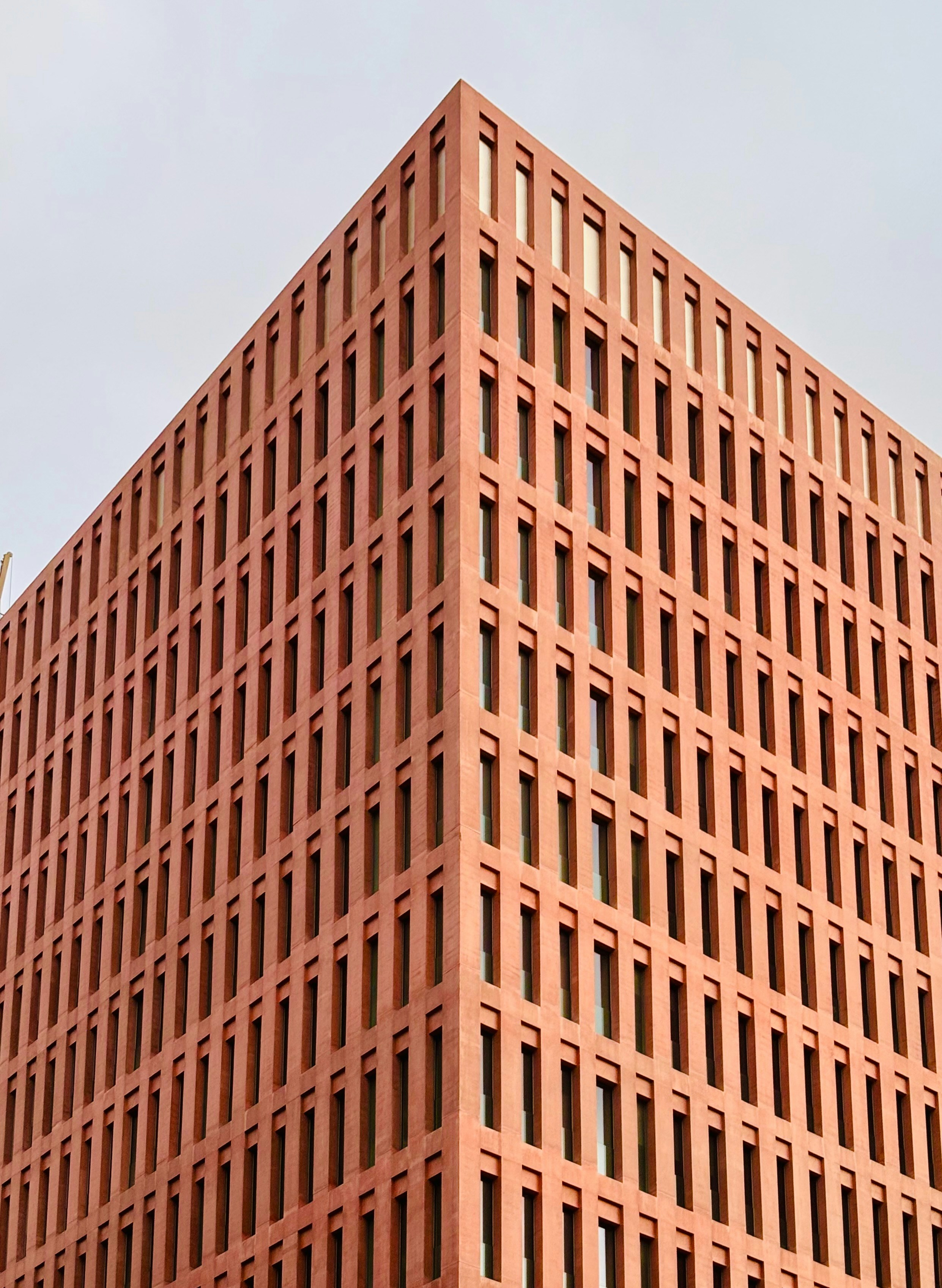 A tall red brick building sitting next to a traffic light photo – Free ...