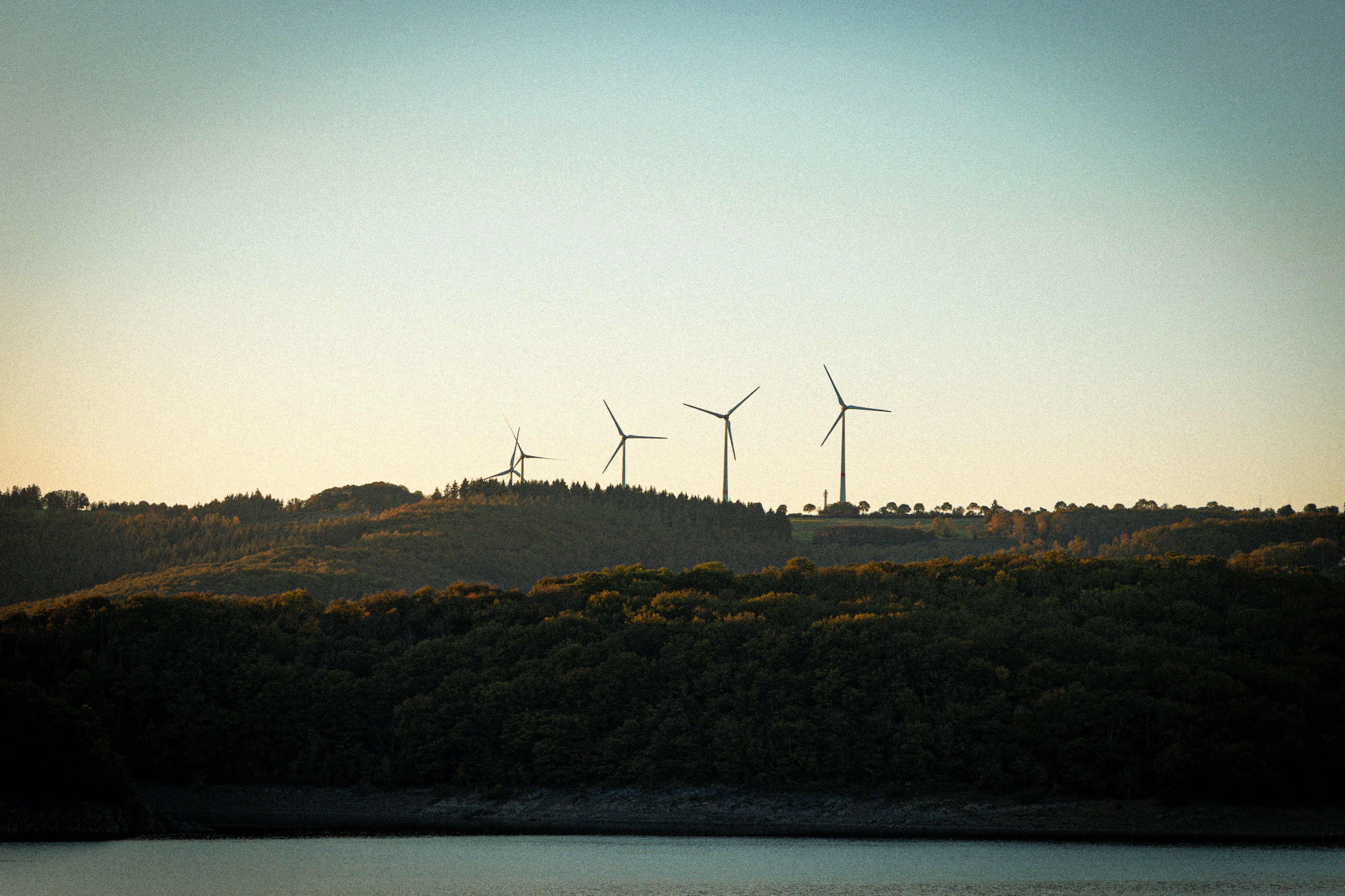 Wind Silent at Dusk: A Row of Turbines on a Coastal Ridge