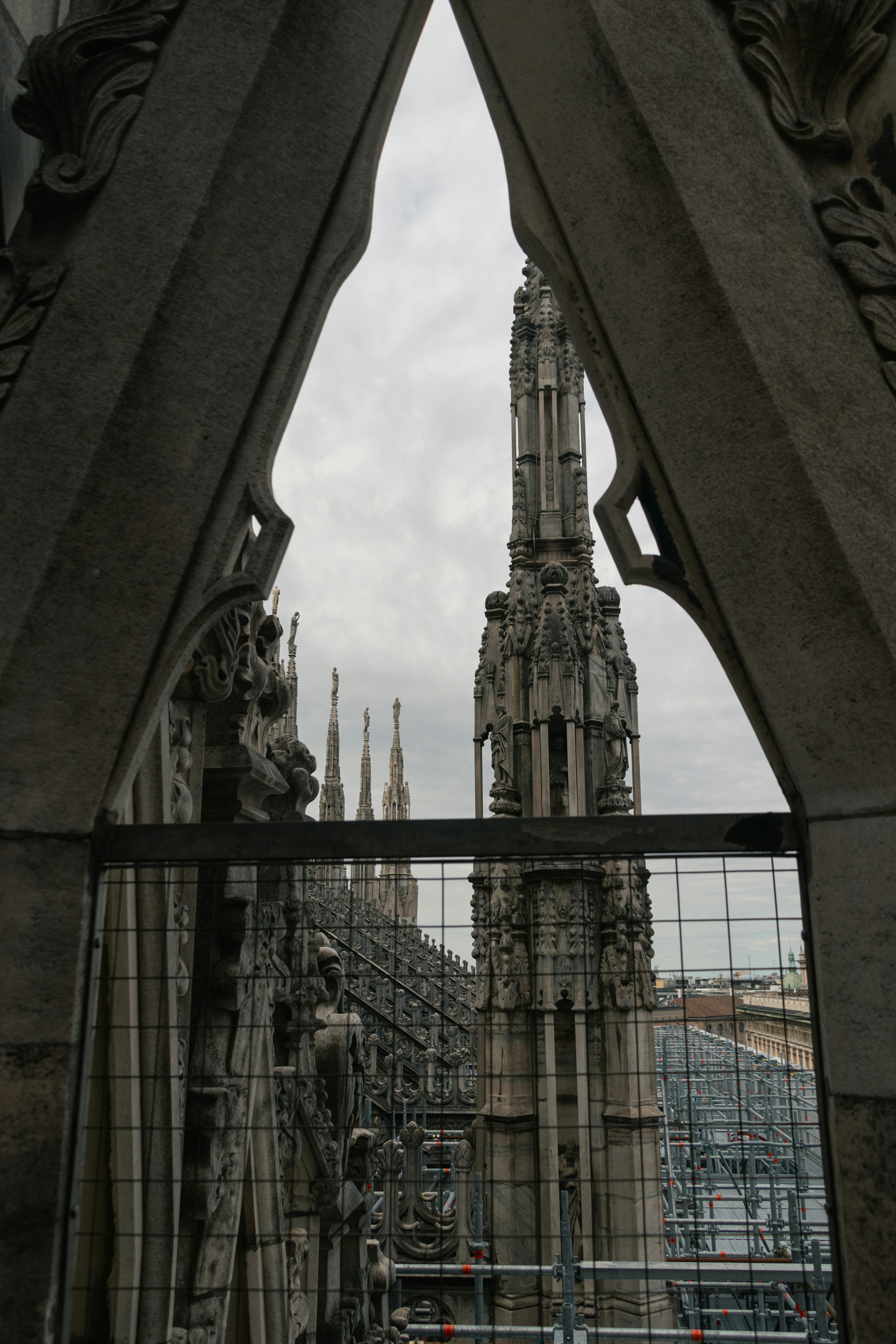 Skyward Needle Framed by Stone: Restoration Under a Gothic Arch