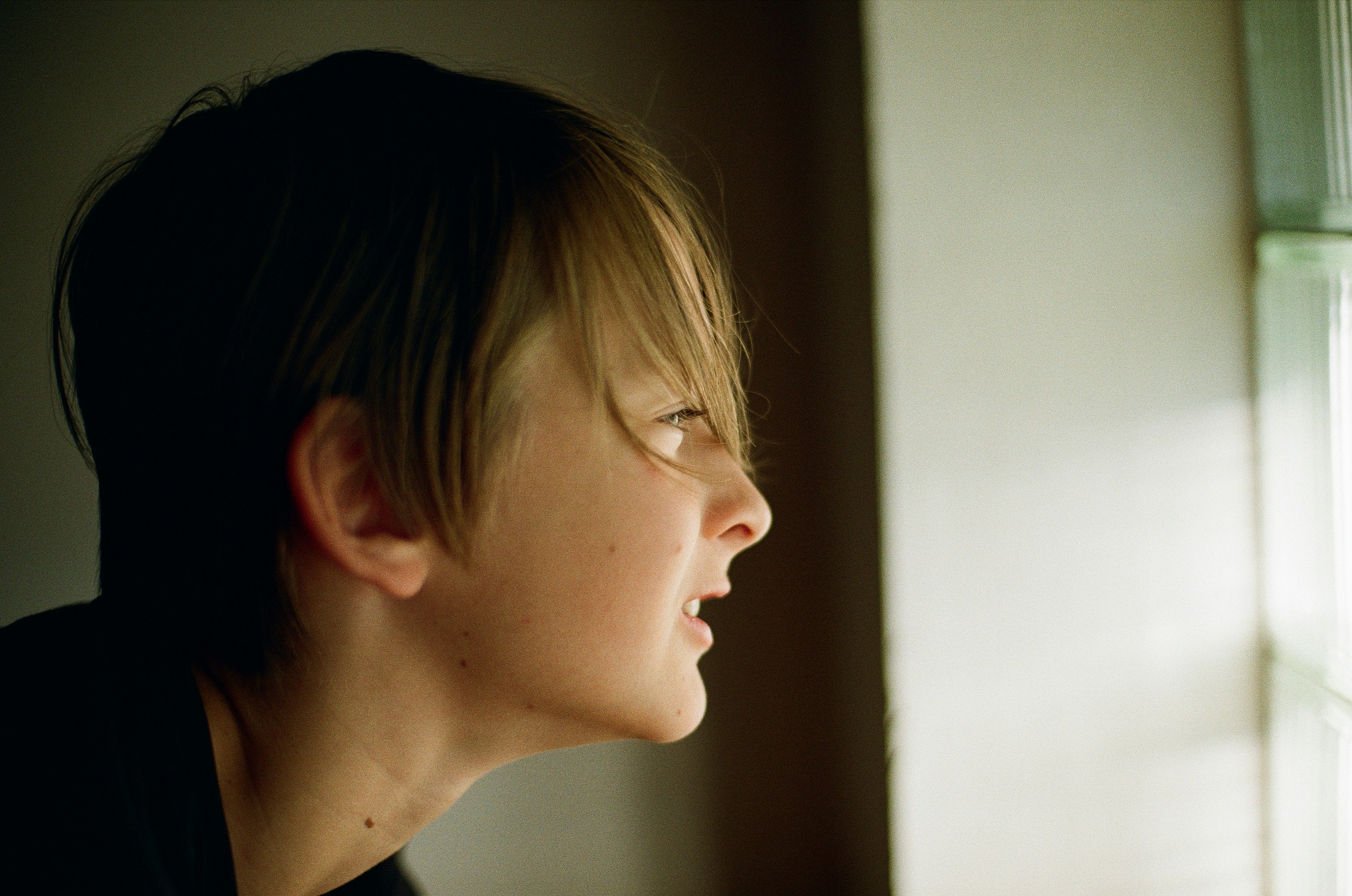 A woman looking out a window at the outside photo – Free Portrait Image ...