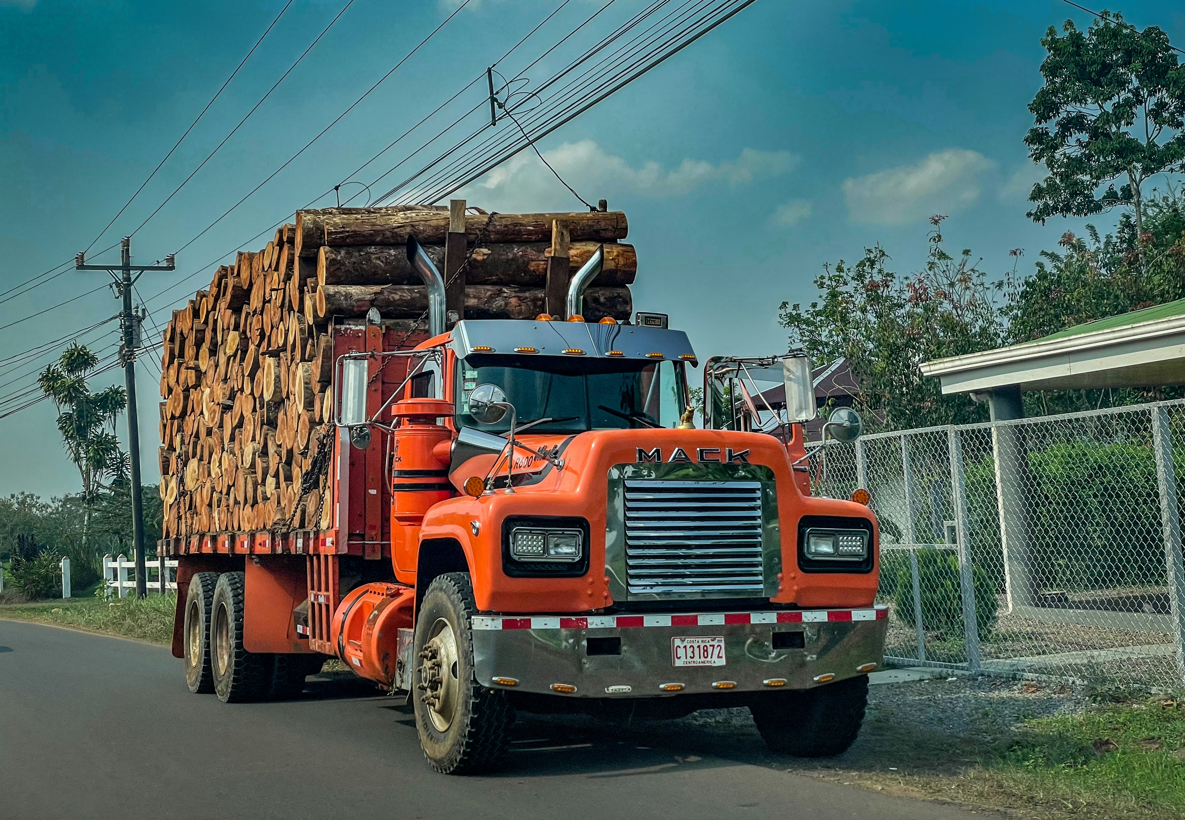 Crimson Logging Hauler Dominates a Quiet Country Road