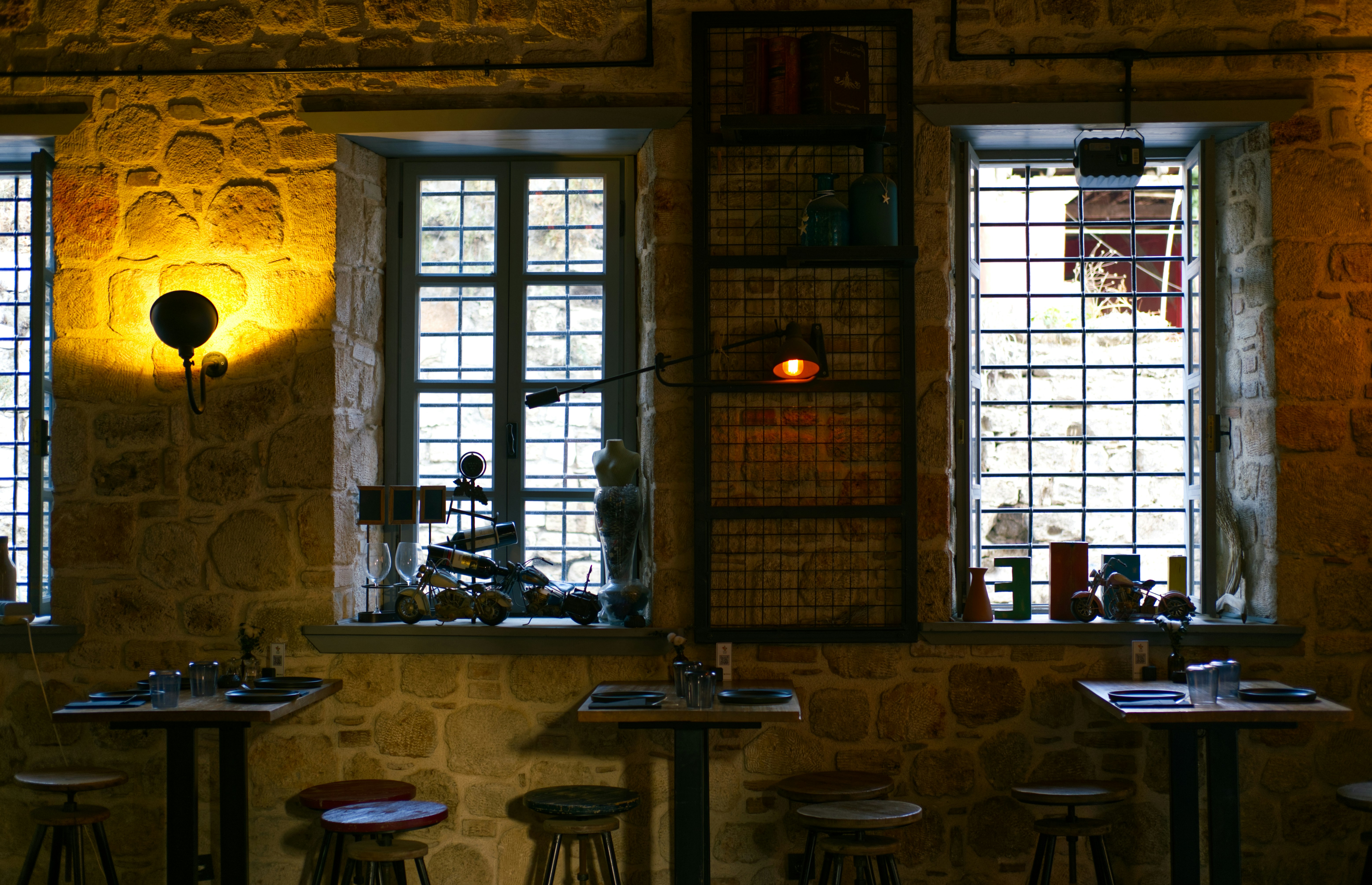 A dimly lit room with three windows and stools photo – Free Building ...