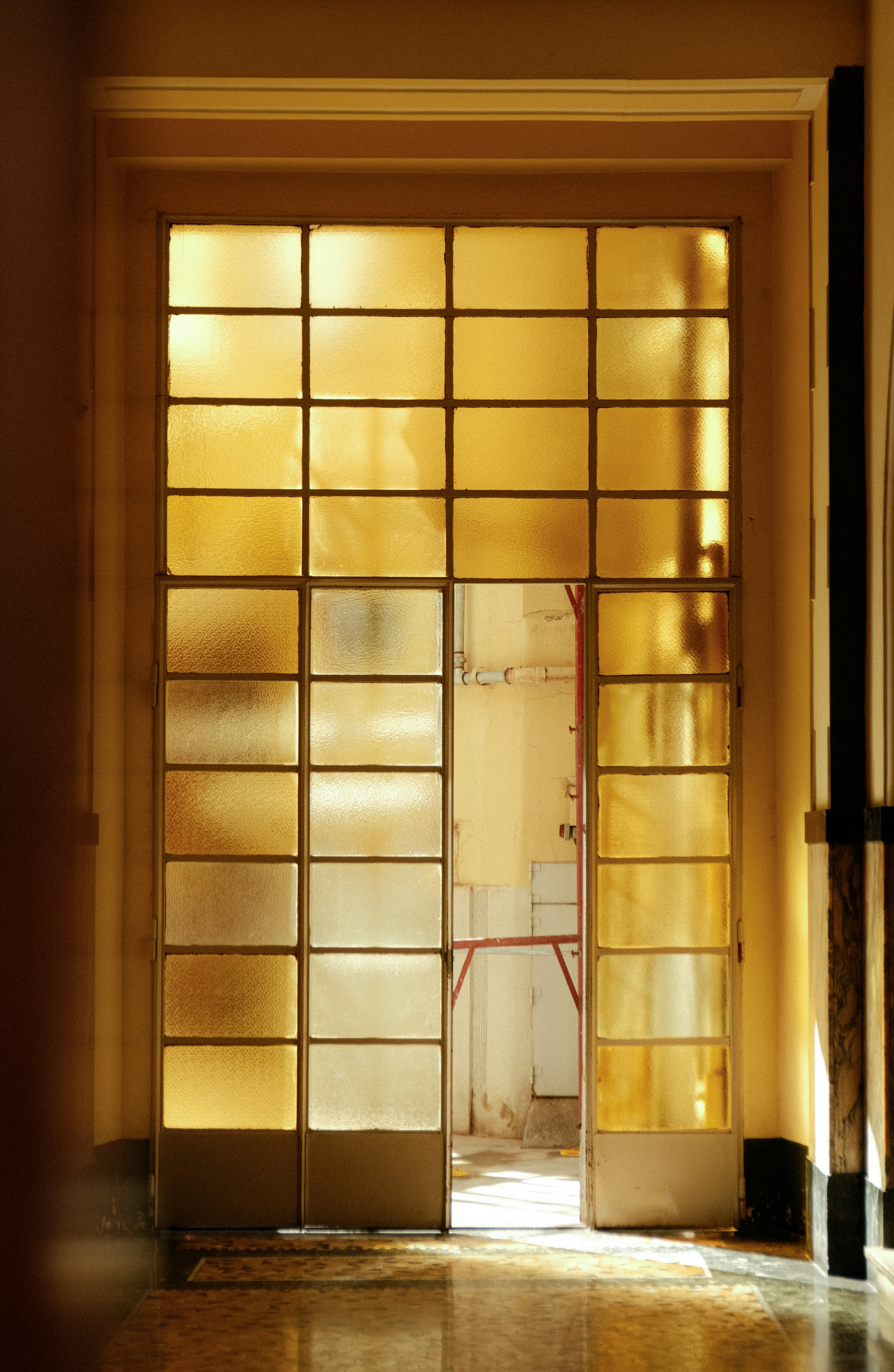 Amber Threshold: Warm Light Through a Grid of Glass Panels