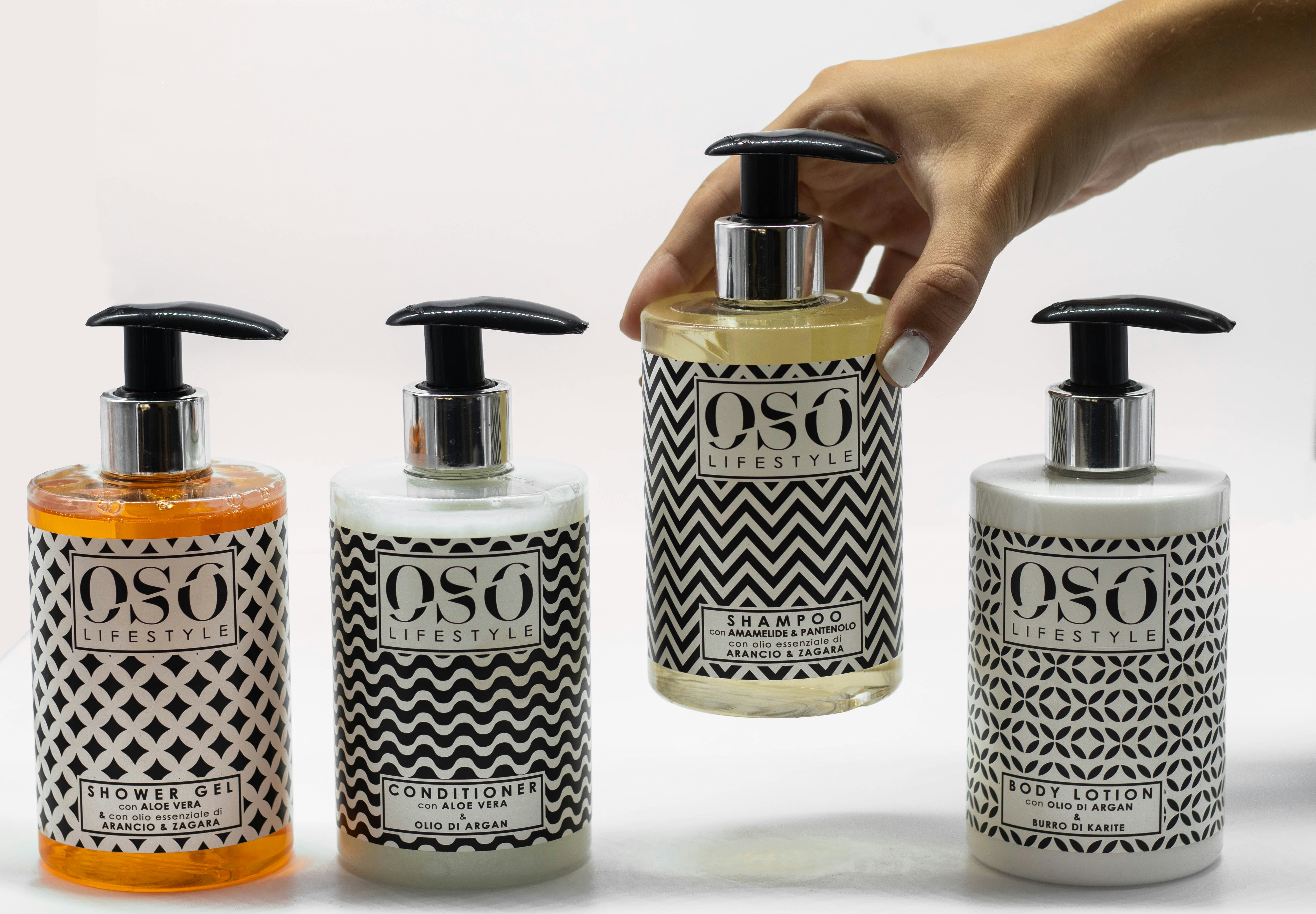 A hand is holding a soap dispenser in front of a row of photo – Free ...