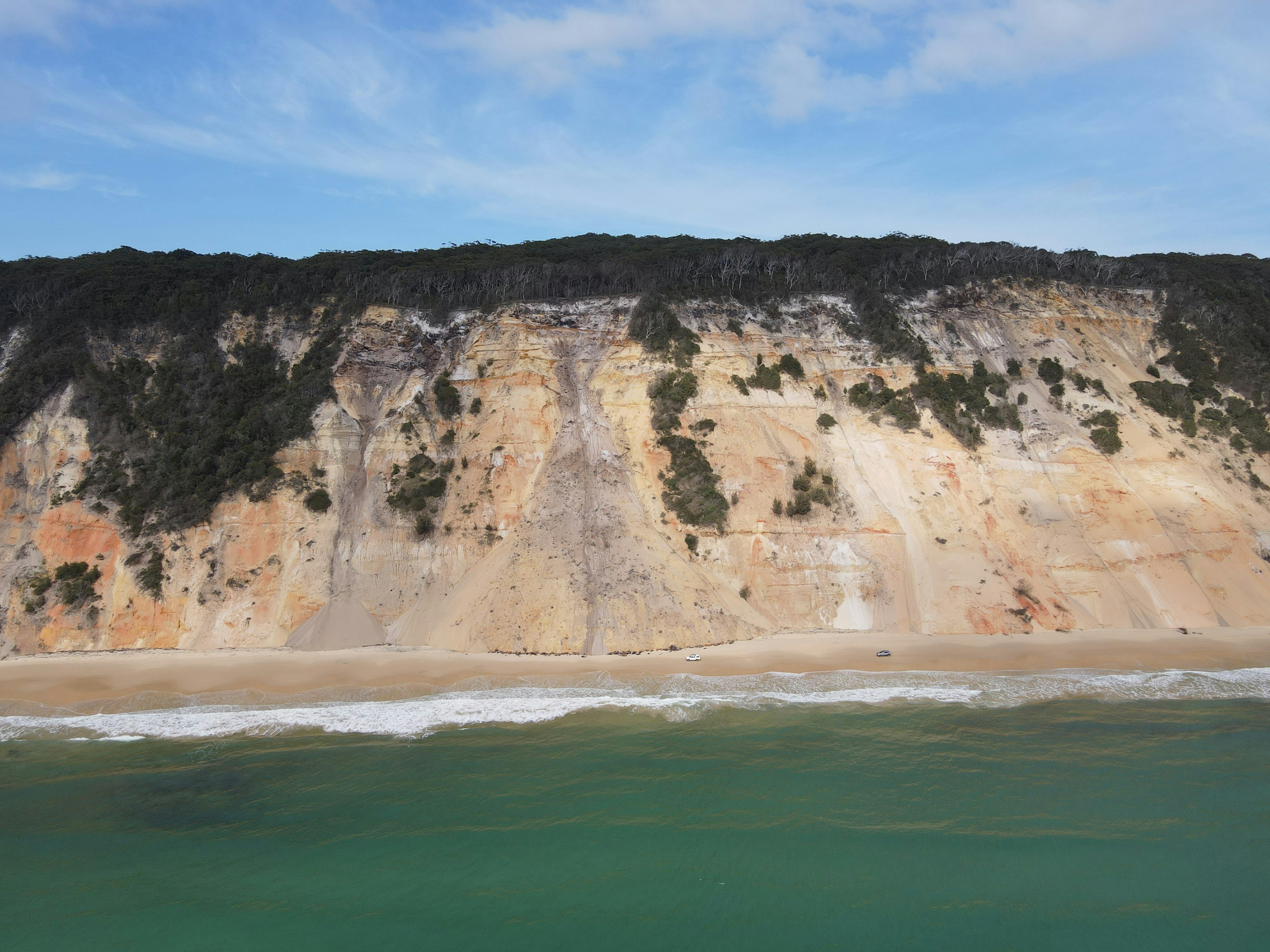 A large cliff on the side of a beach photo – Free Sea Image on Unsplash
