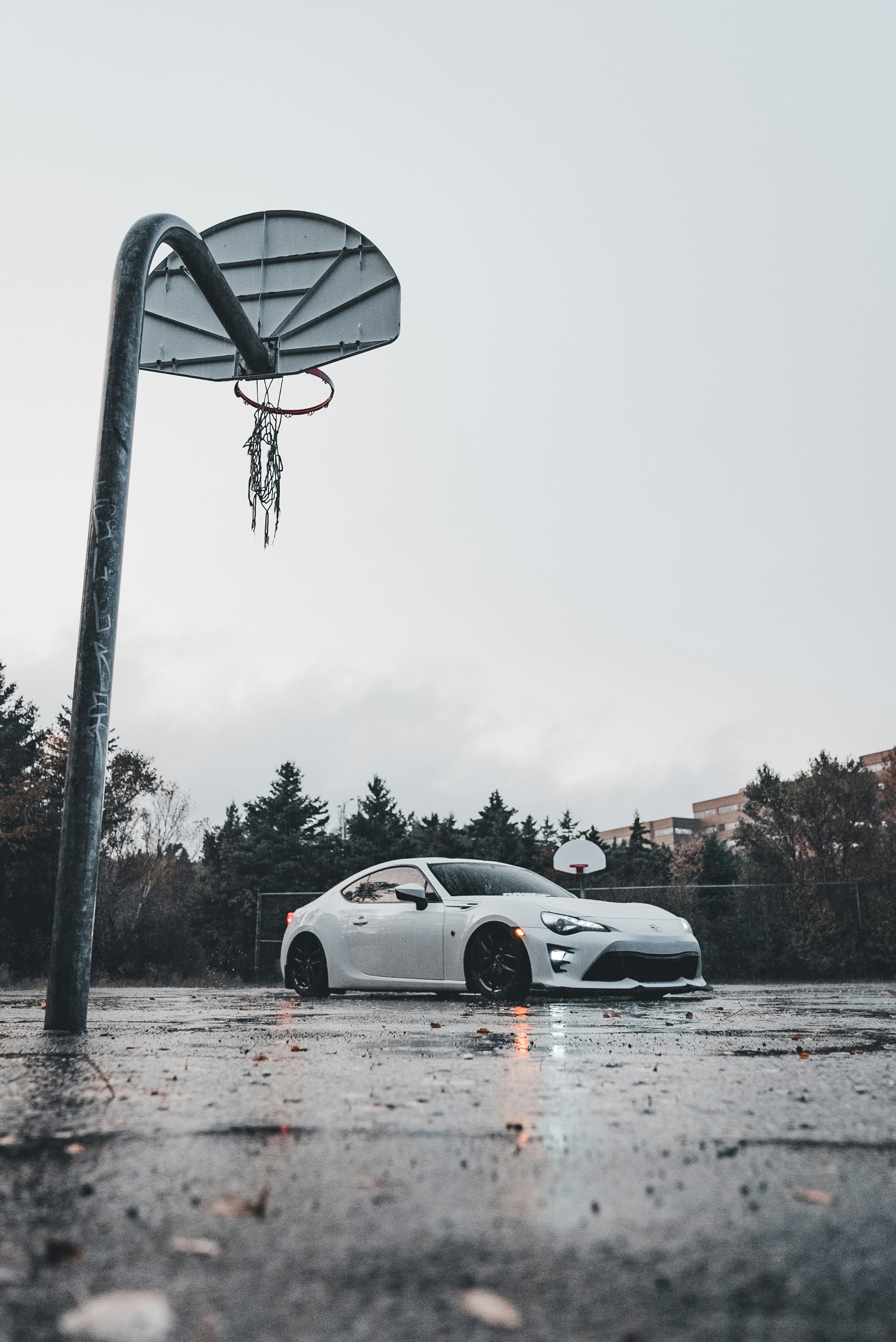 A car parked in a parking lot next to a basketball hoop photo – Free ...