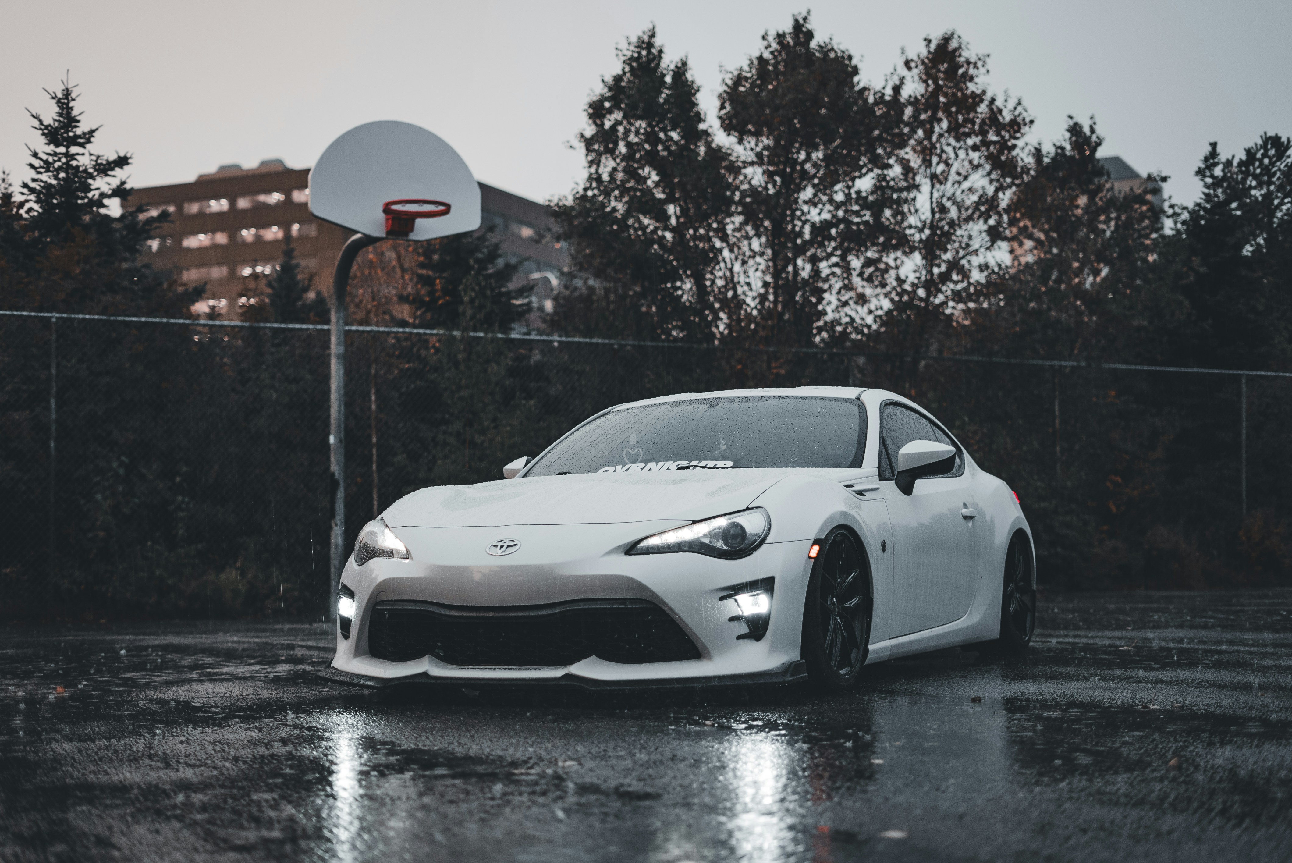 A white sports car parked in front of a basketball hoop photo – Free ...