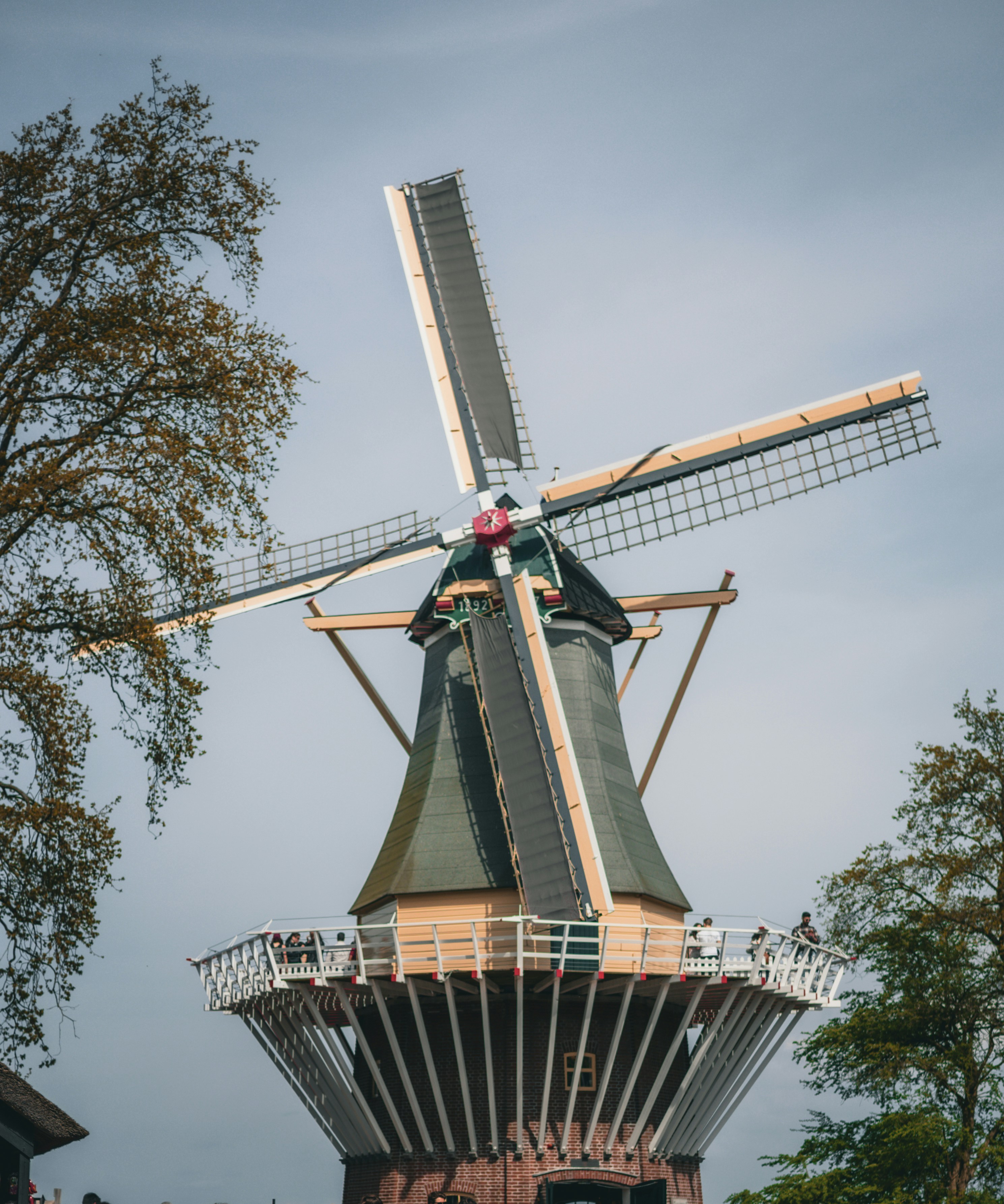 A windmill with a person standing on top of it photo – Free Old Image ...