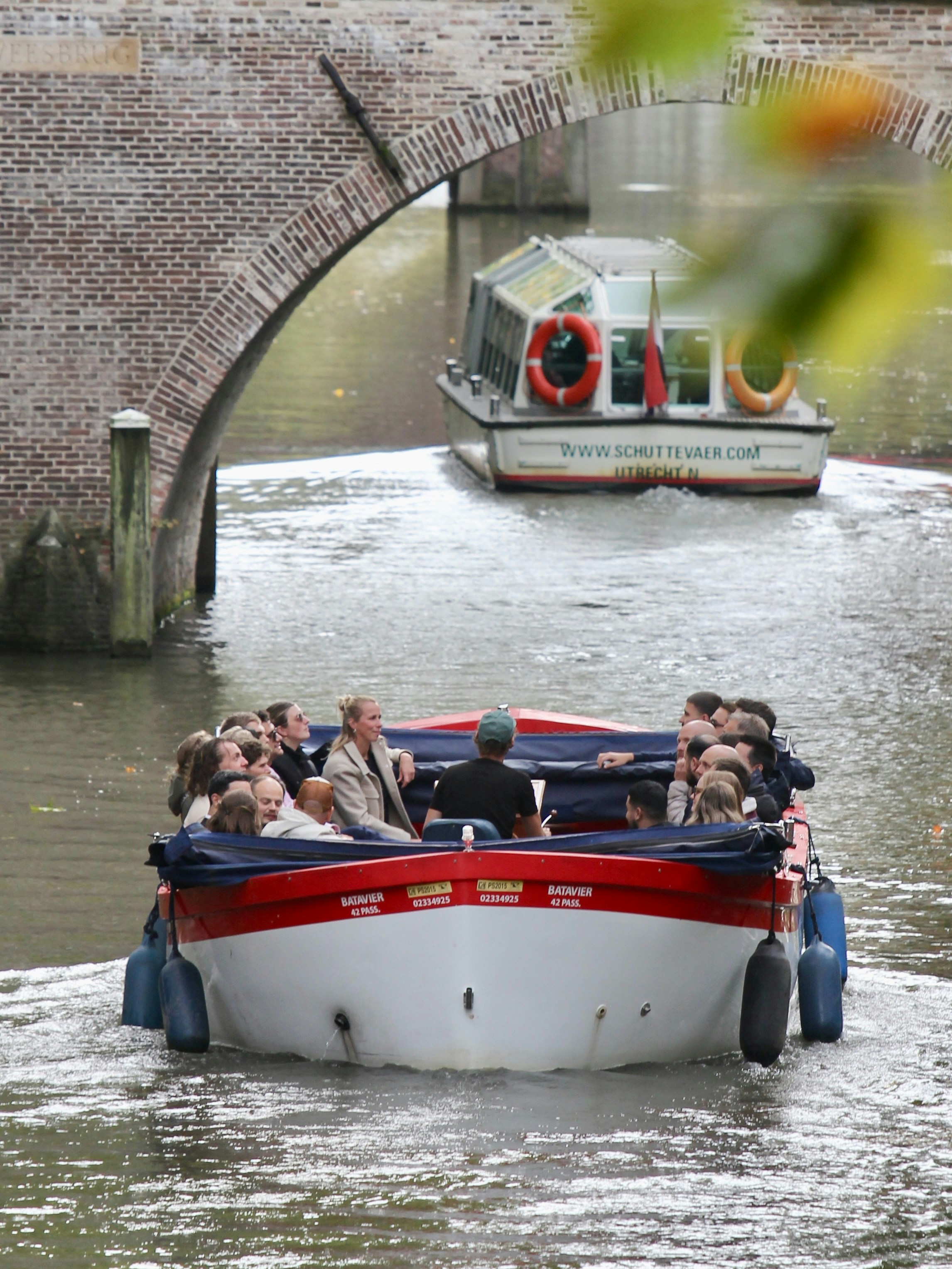 Under the Arch: Crowded Canal Boat in Transit