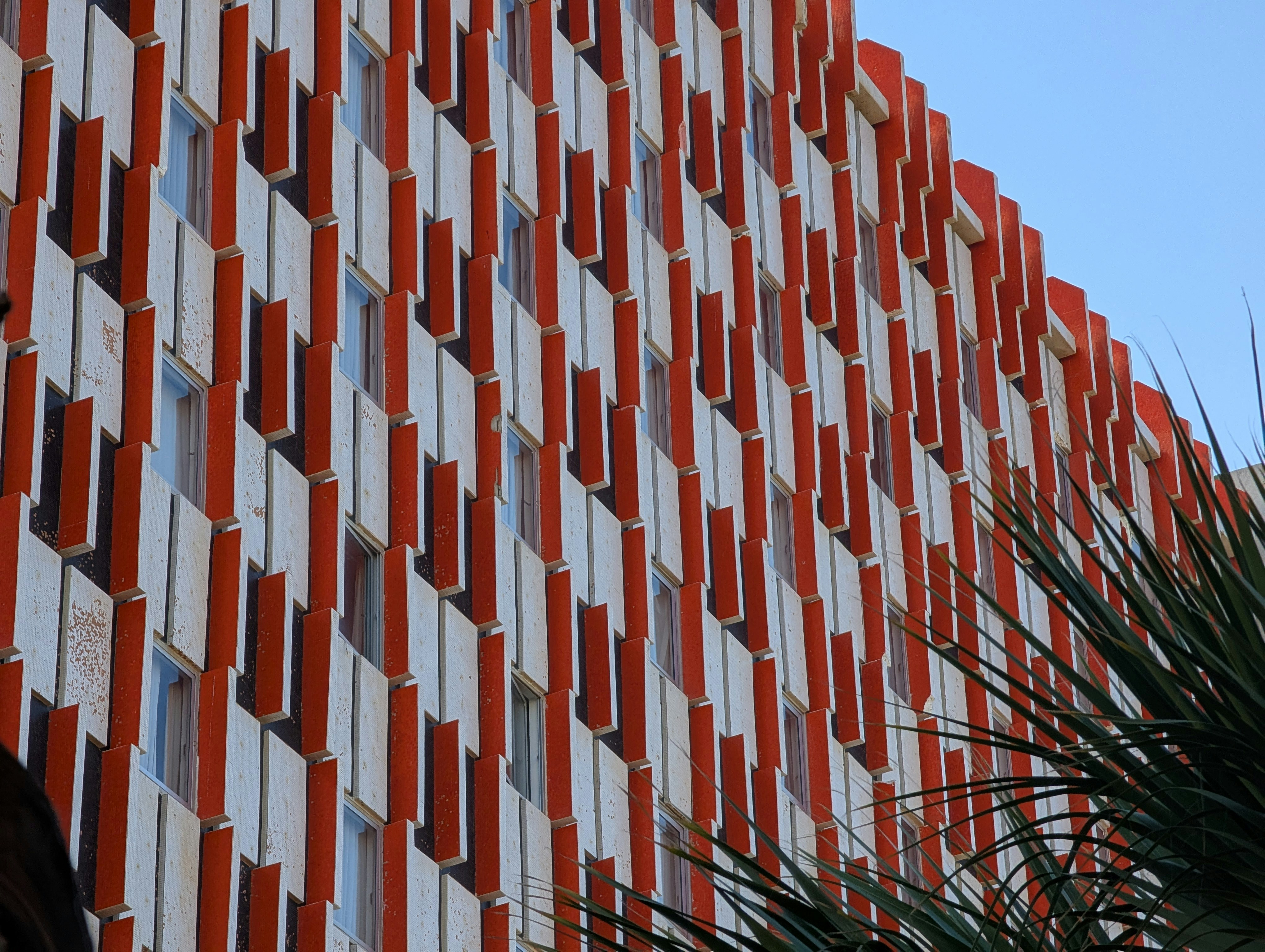 Red-and-White Facade: A Matte Dance of Rectangles Against Sky