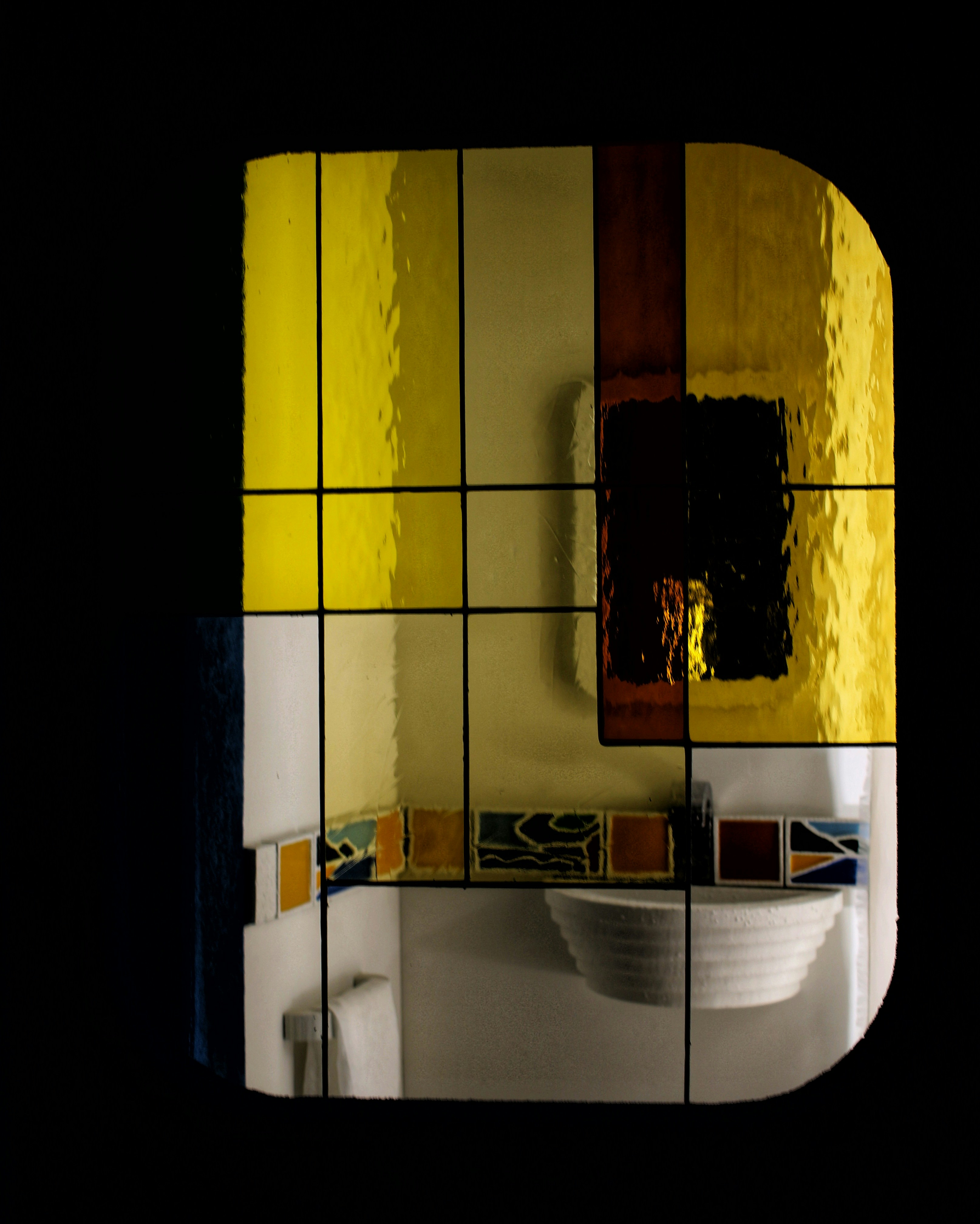Amber Grid Window: Backlit Stained-Glass Framing a Quiet Bathroom Nook