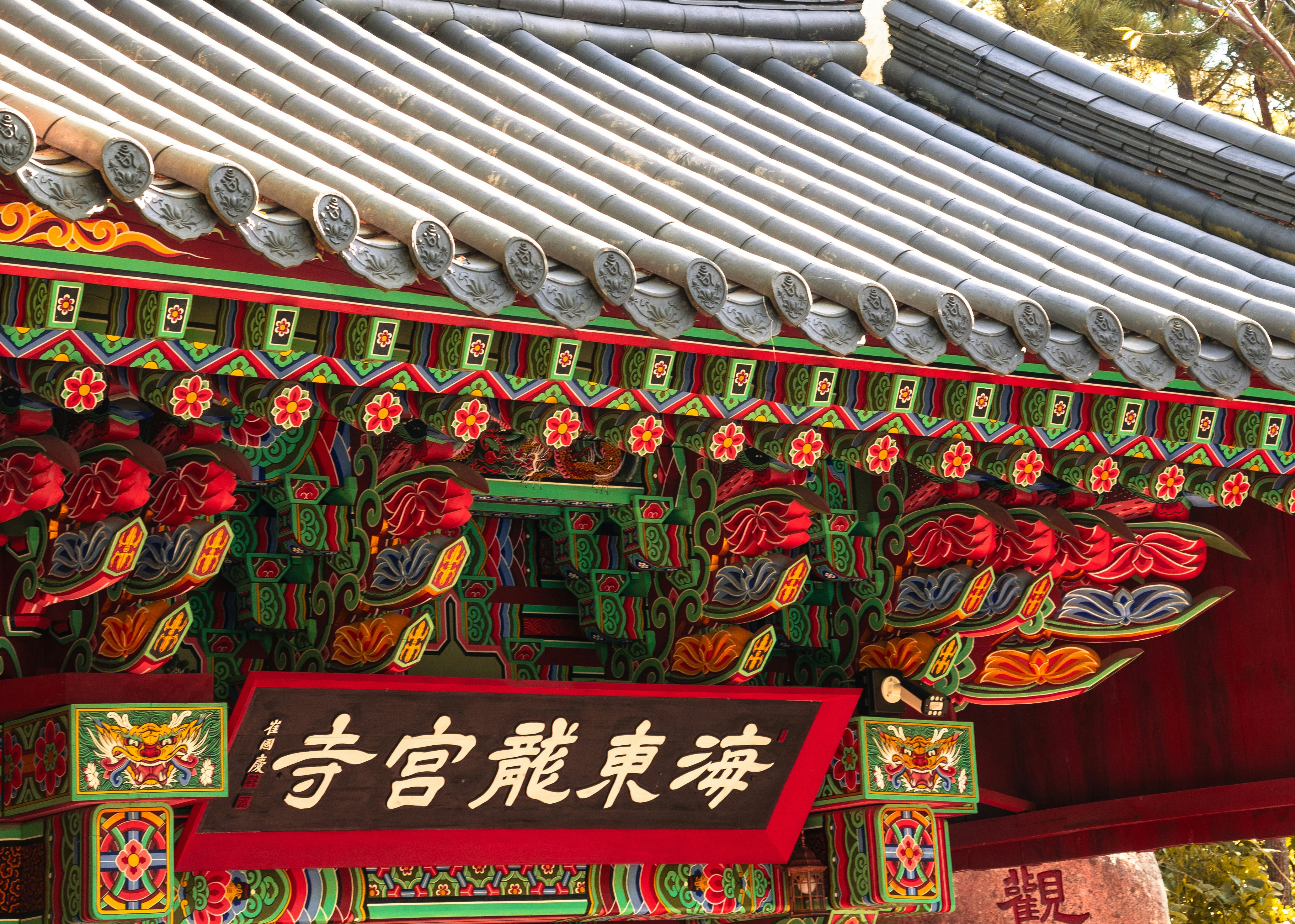 Under the Painted Eaves: Temple Signboard Adorned with Vibrant Carvings