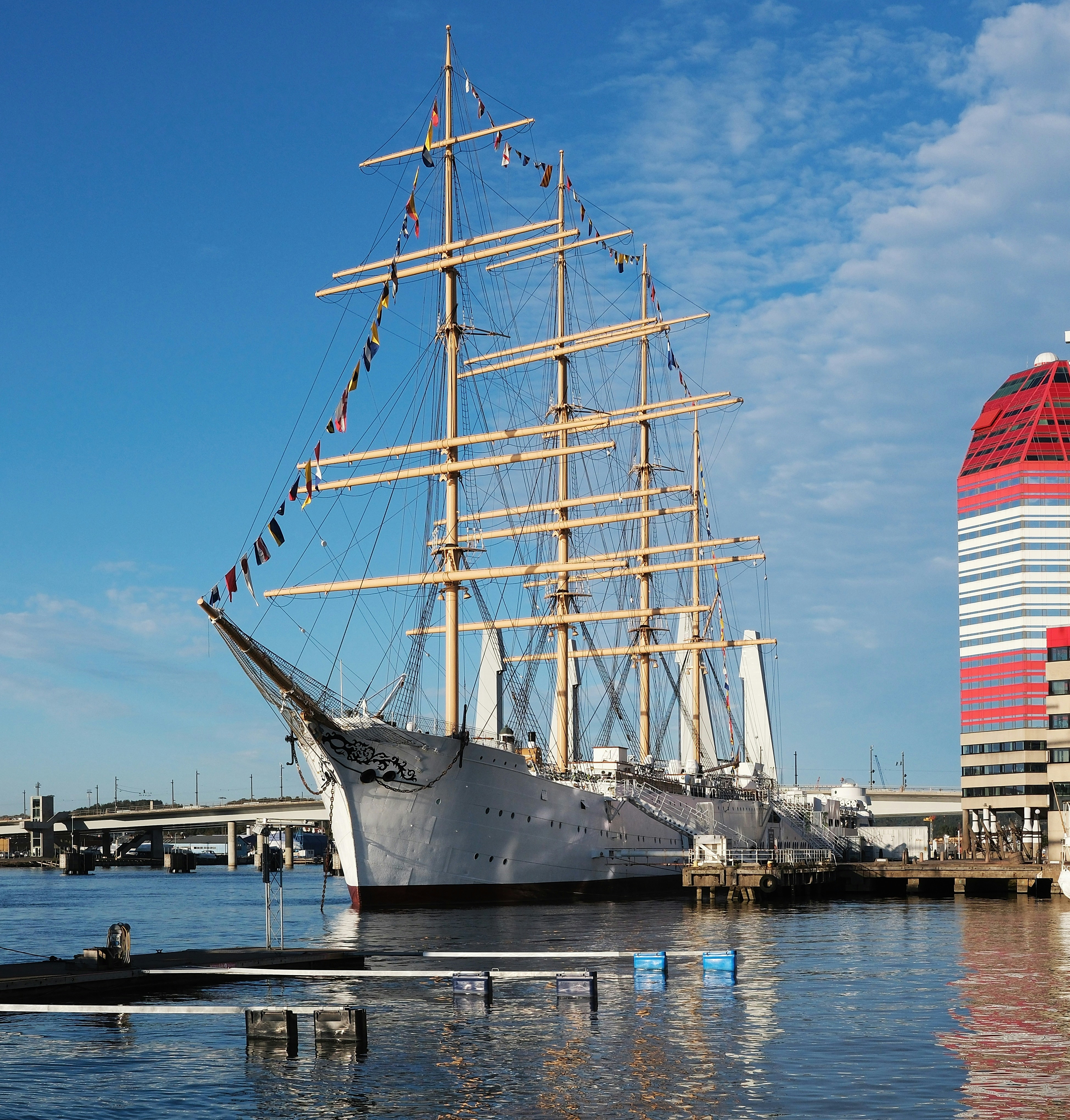 Three-Masted Clipper by a Striped Skyline in a Quiet Harbor