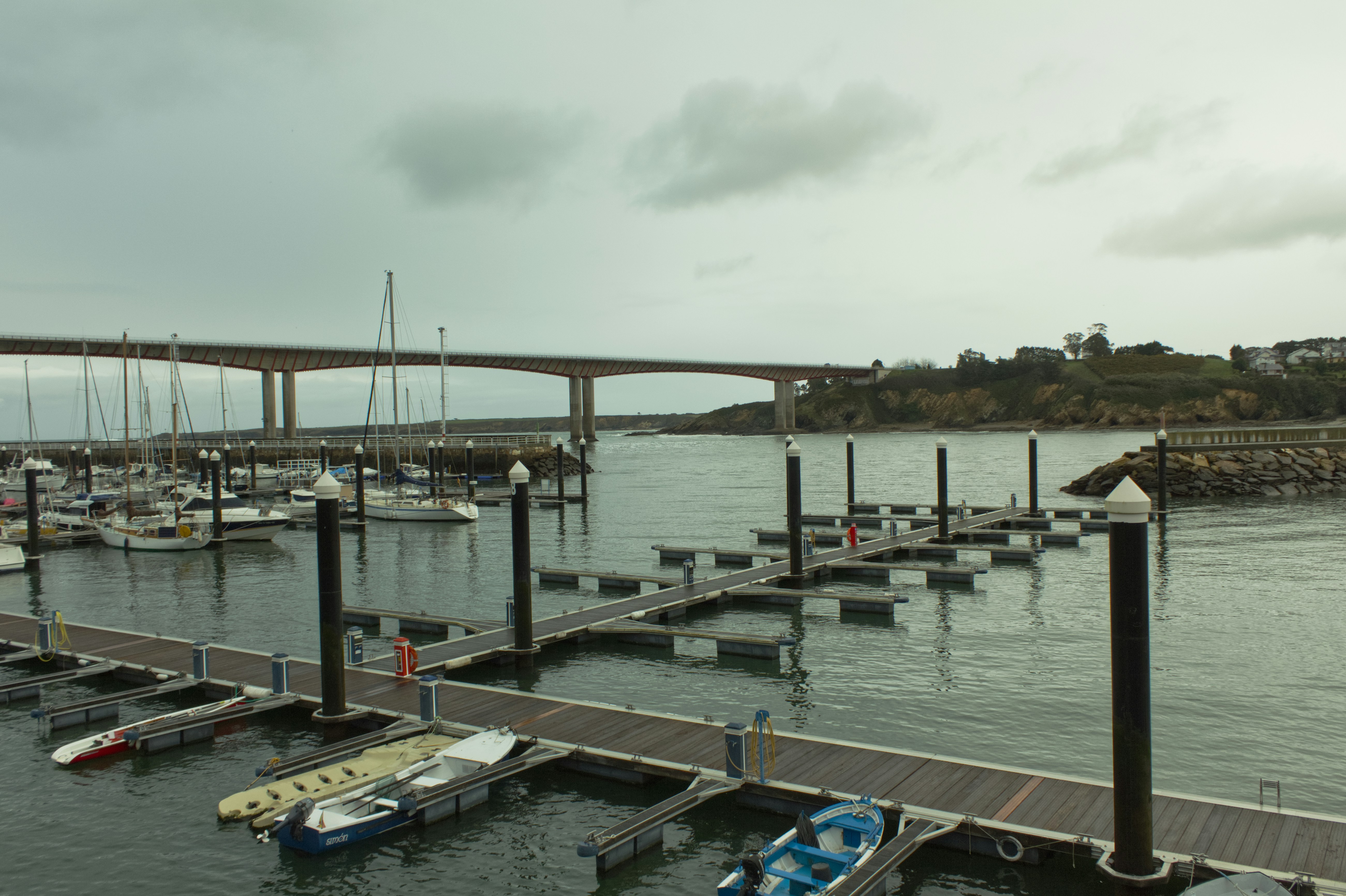 A harbor filled with lots of boats under a bridge photo – Free Port ...