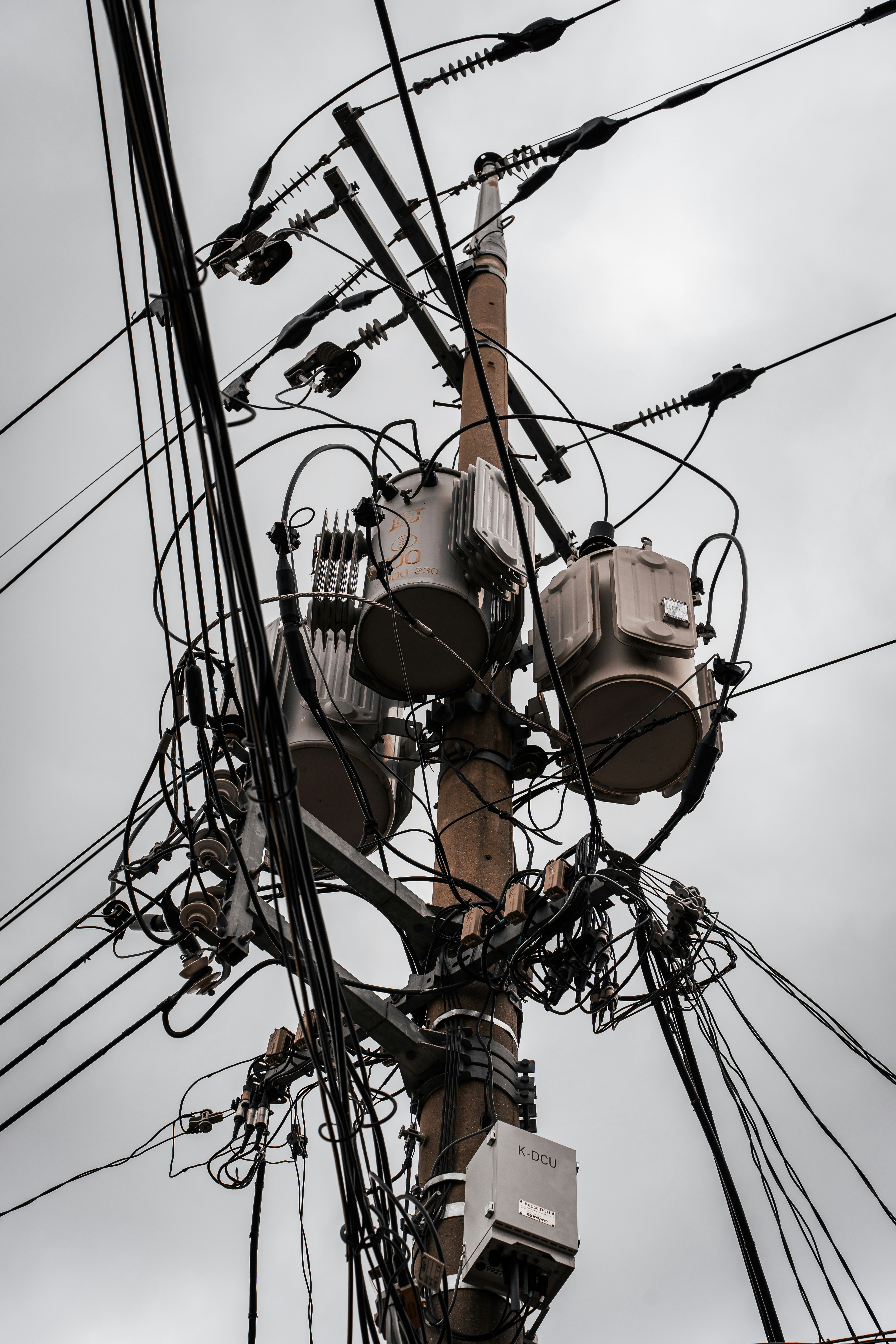 Pole of Threads: A Dense Web of Electric Lifelines Against a Gray Sky