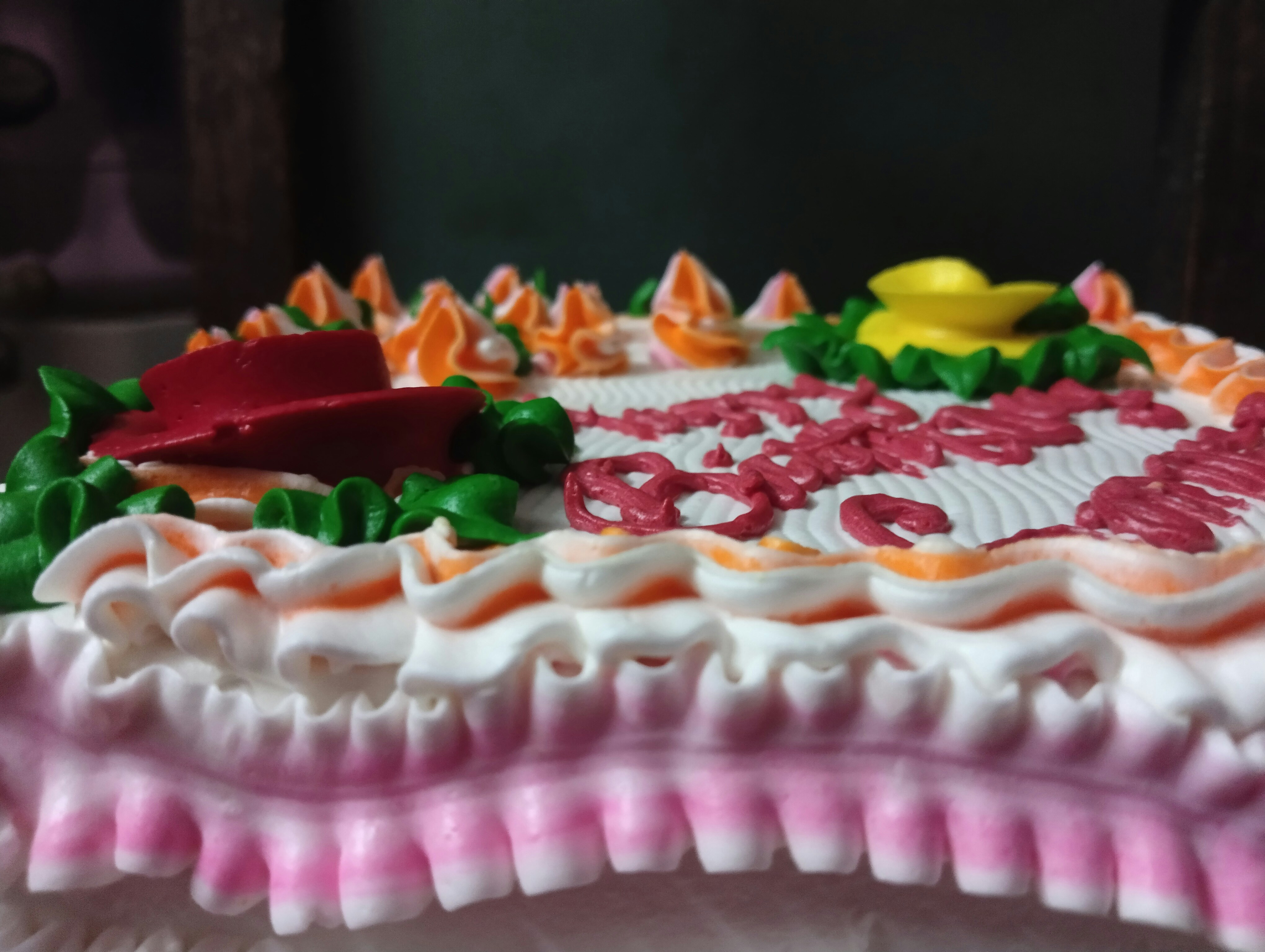 Close-up Celebration: Ornate Frosting and Colorful Edible Details on a Layered Cake
