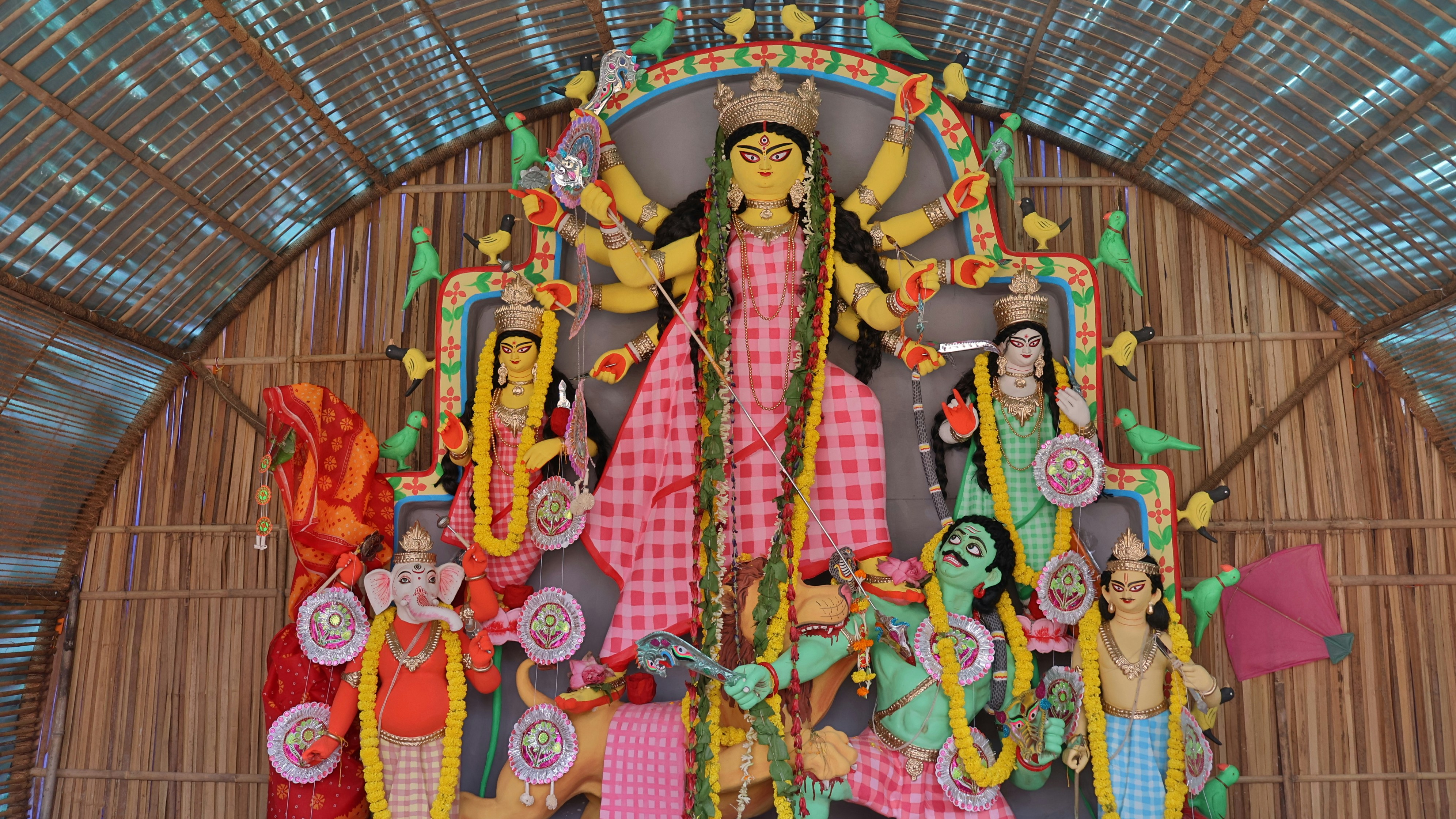 Colorful statue of a multi-armed goddess surrounded by attendants in a decorative setting.