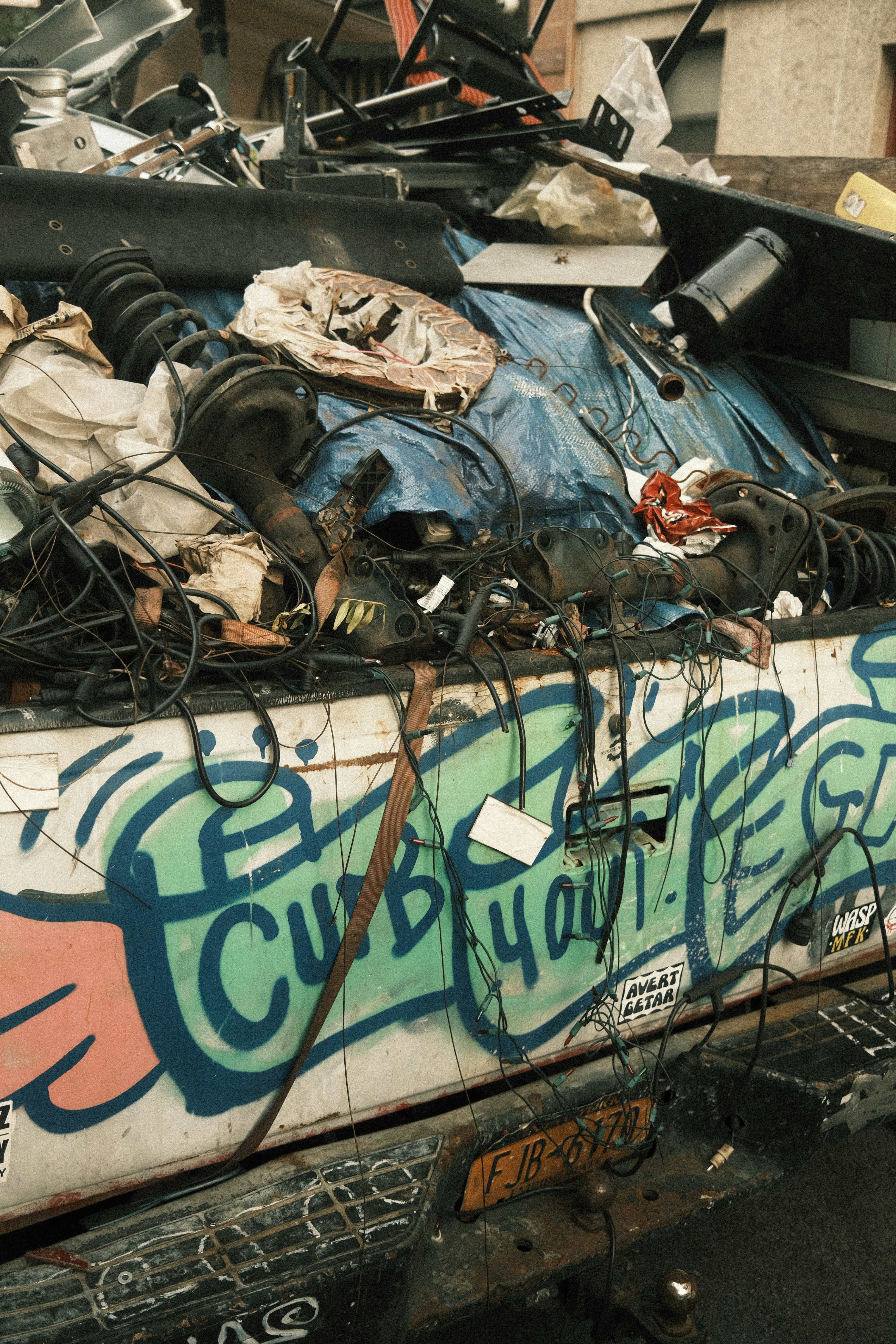 Graffiti Hauler: tangled relics spilling from a weathered truck bed