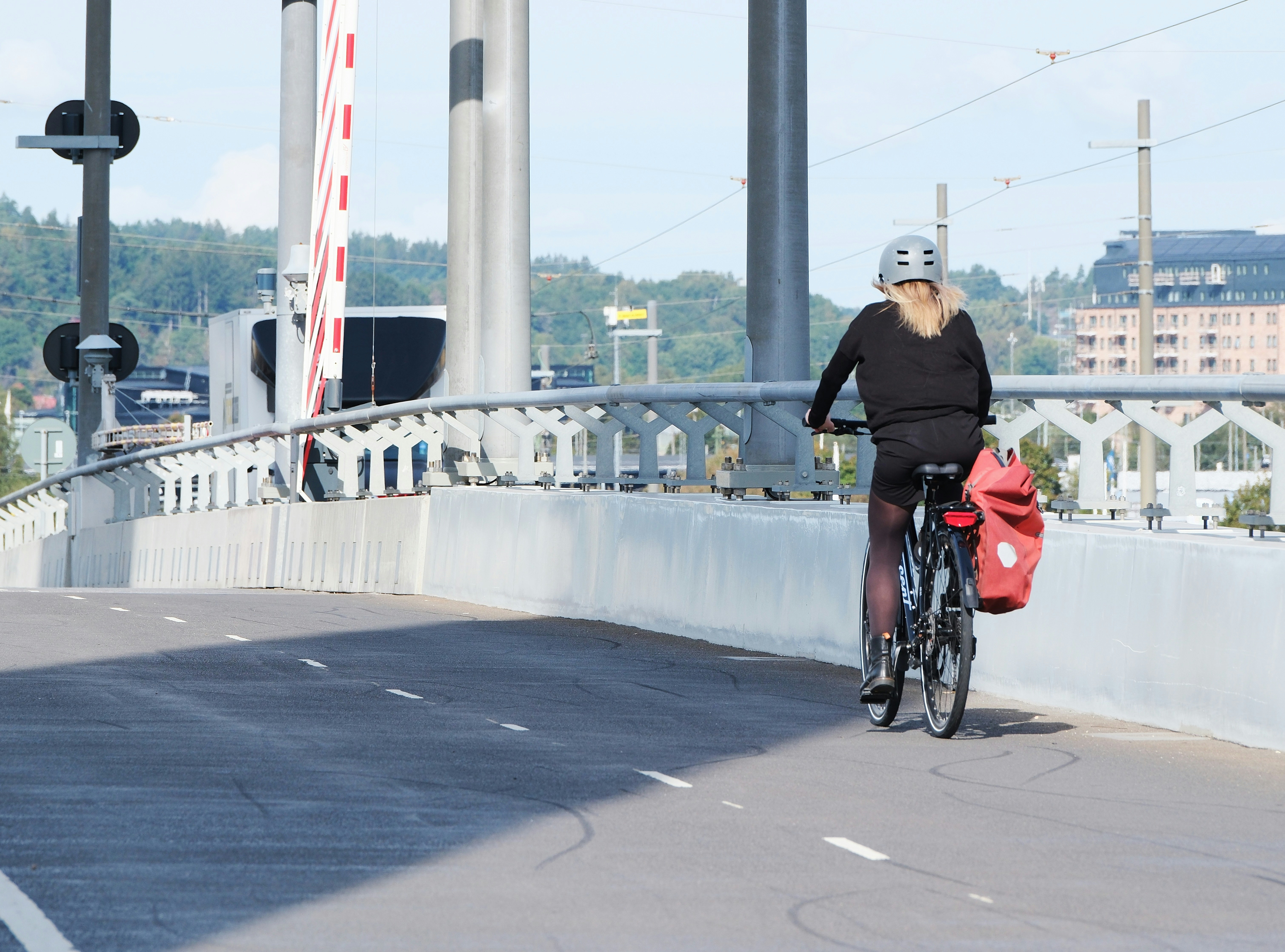 A woman riding a bike across a bridge photo – Free Sweden Image on Unsplash