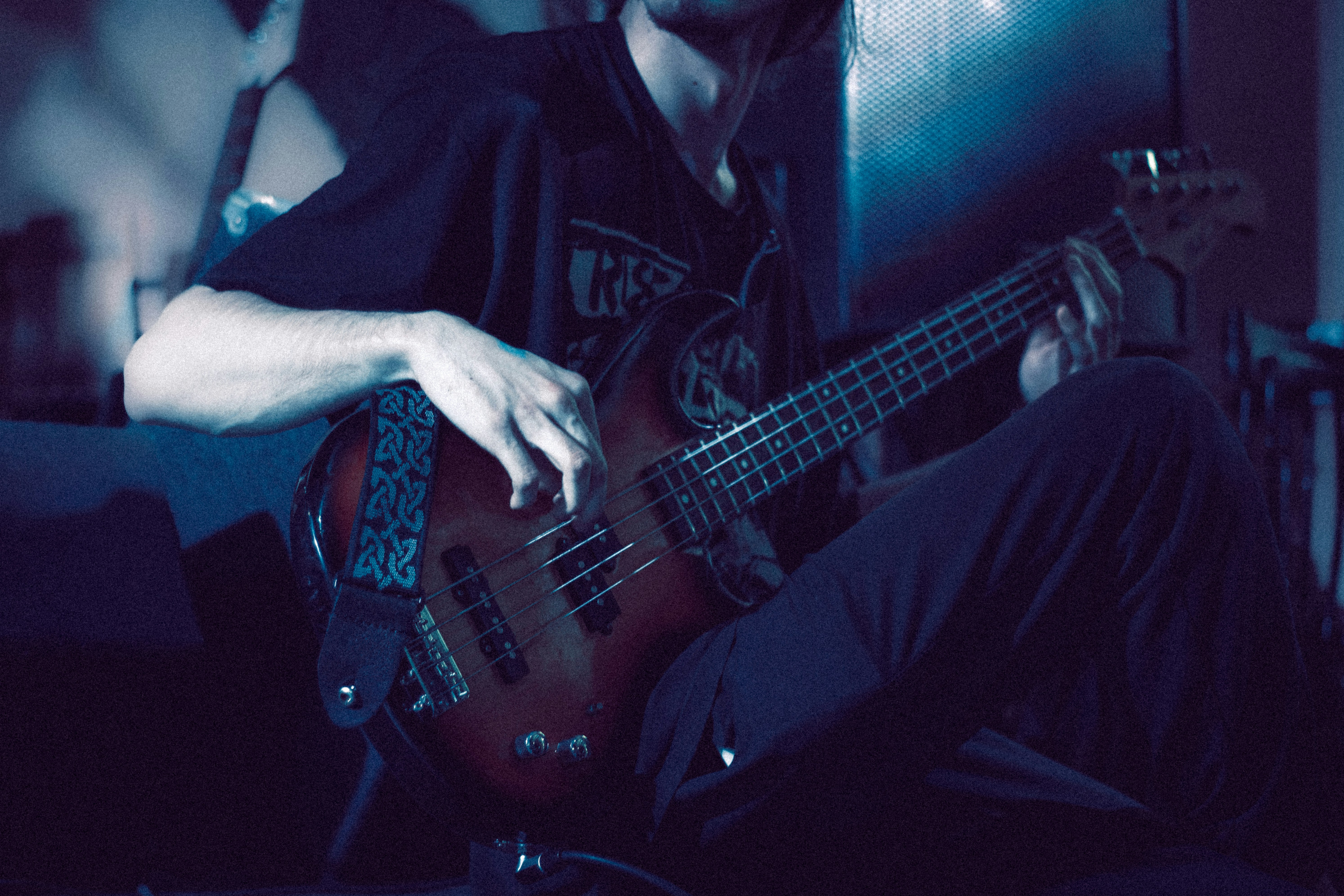 Blue-hour Bass: Fingers on the Neck in a Dim Rehearsal